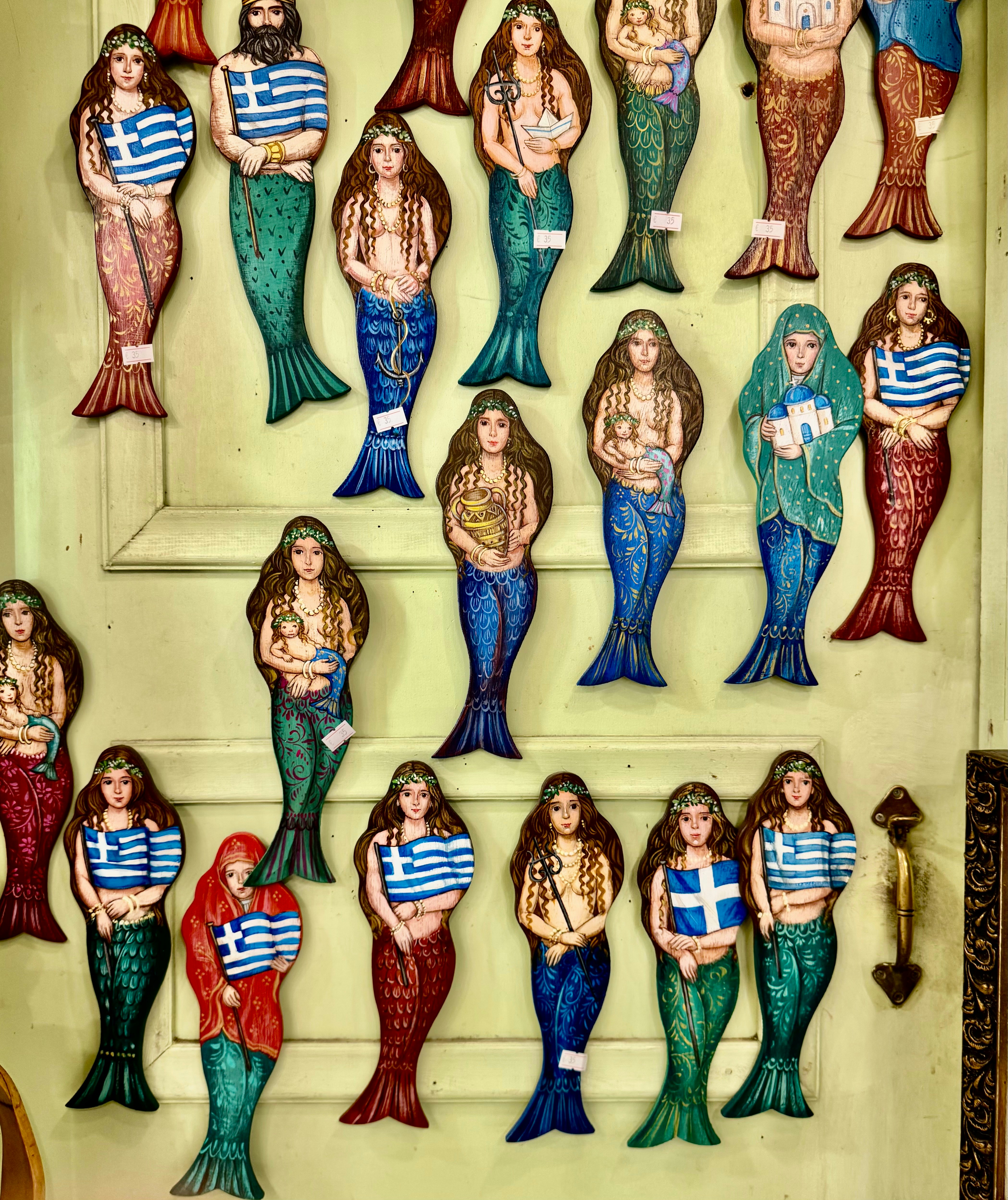 Mermaid figures holding greek flags are displayed. photo – Free Woman ...