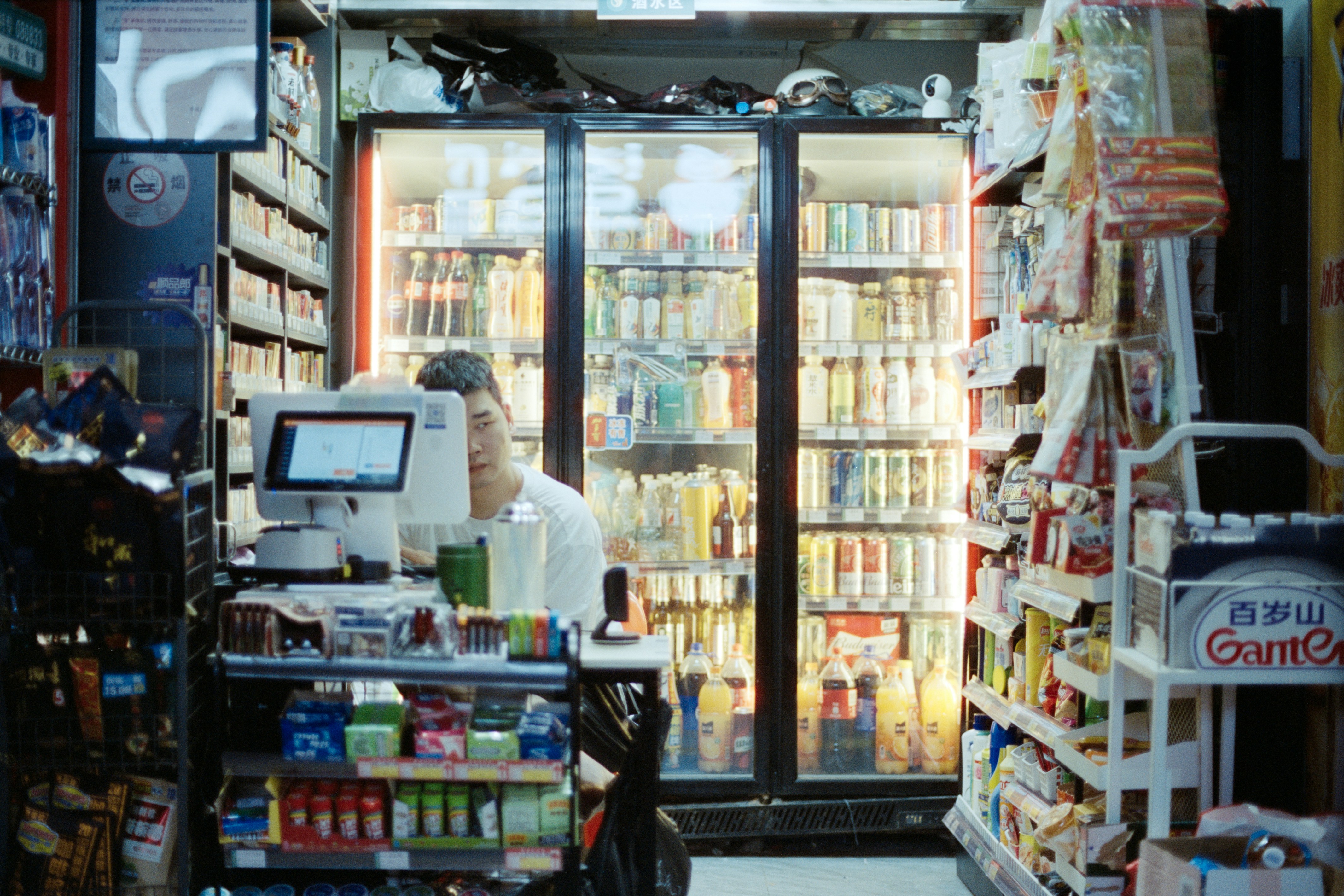 A man stands behind the counter in a store. photo – Free Street ...