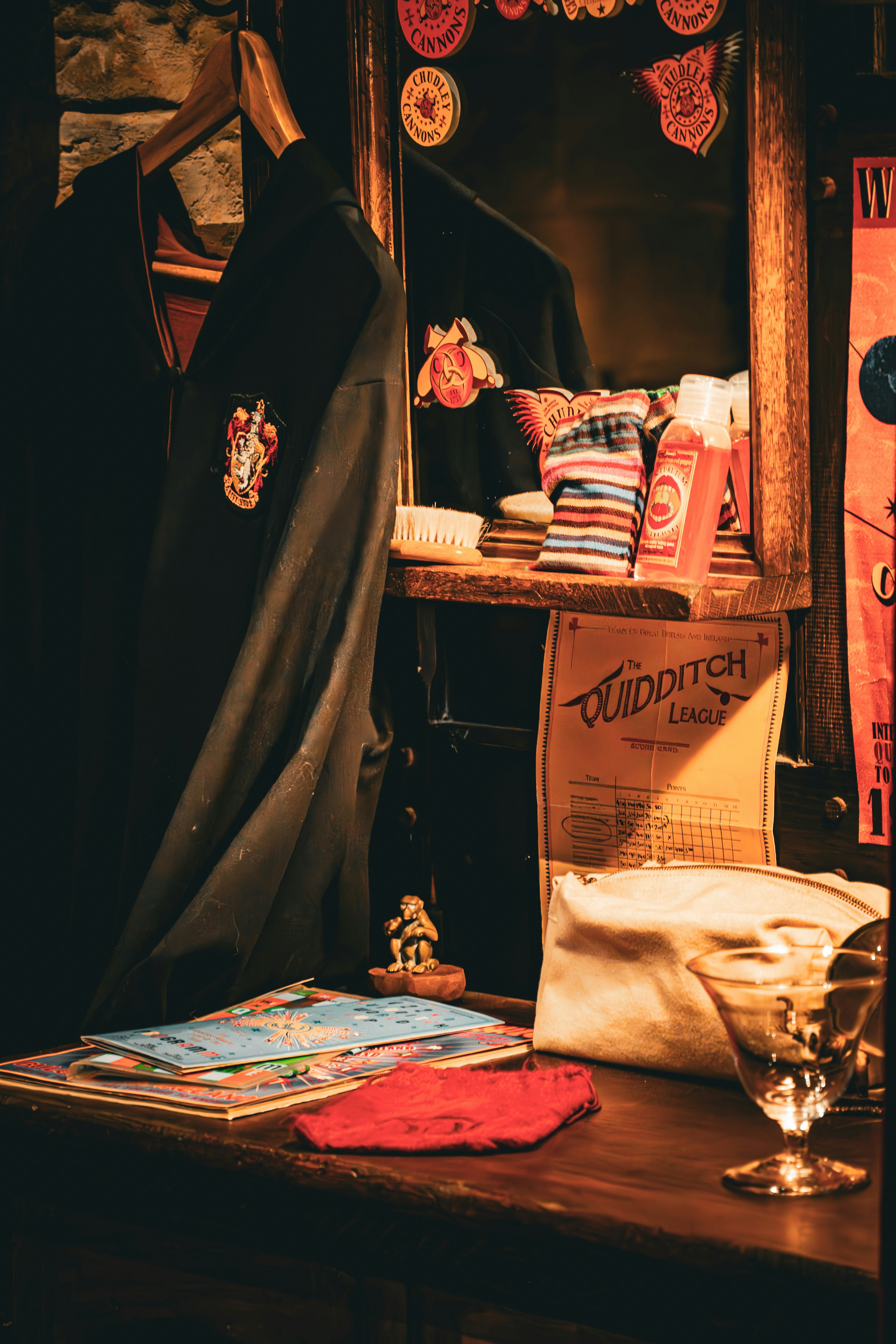 A cozy display featuring a Gryffindor robe, Quidditch League poster, and assorted memorabilia, evoking a sense of nostalgia for the magical world.