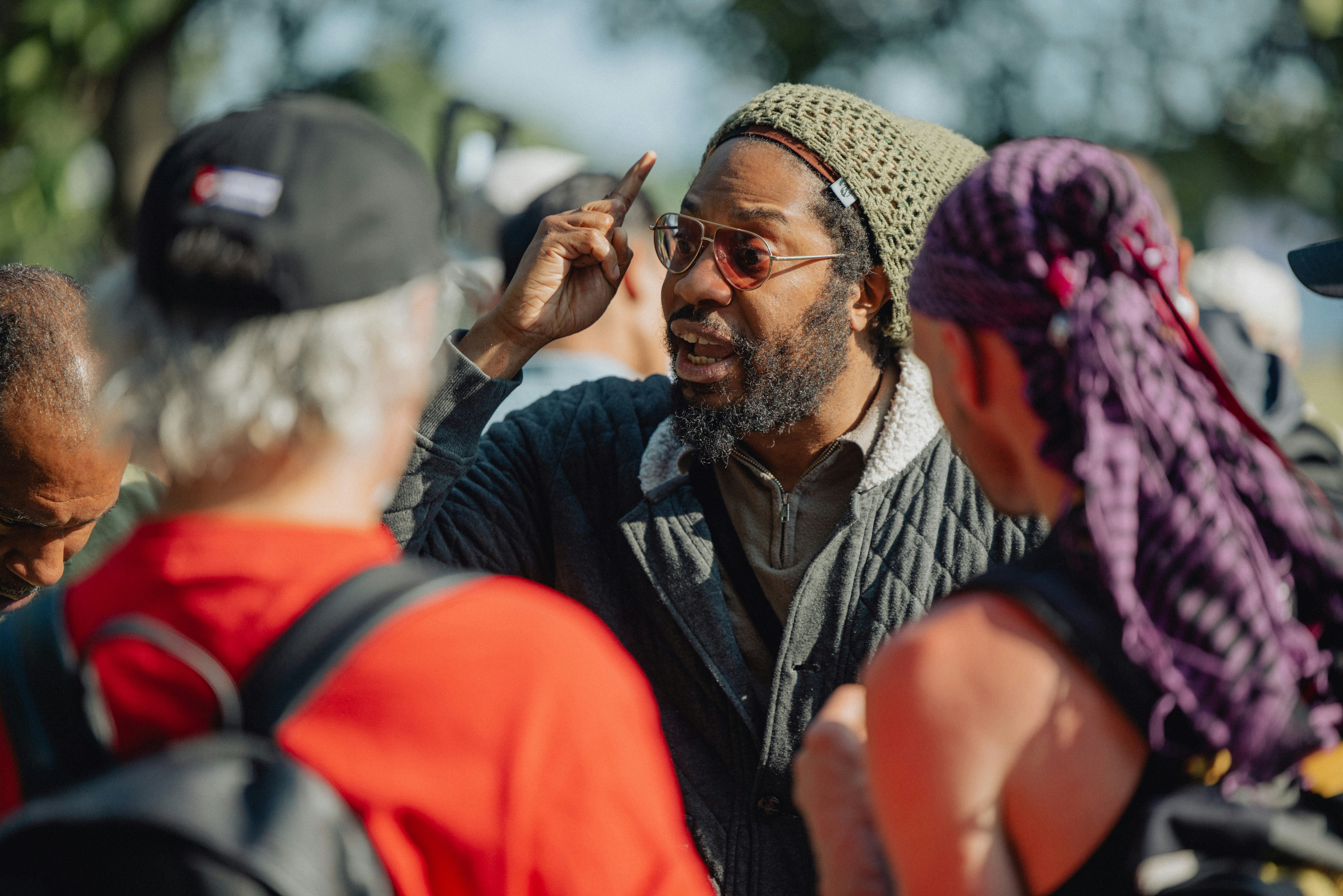 Man gestures while speaking to a small gathering. photo – Free Woman ...