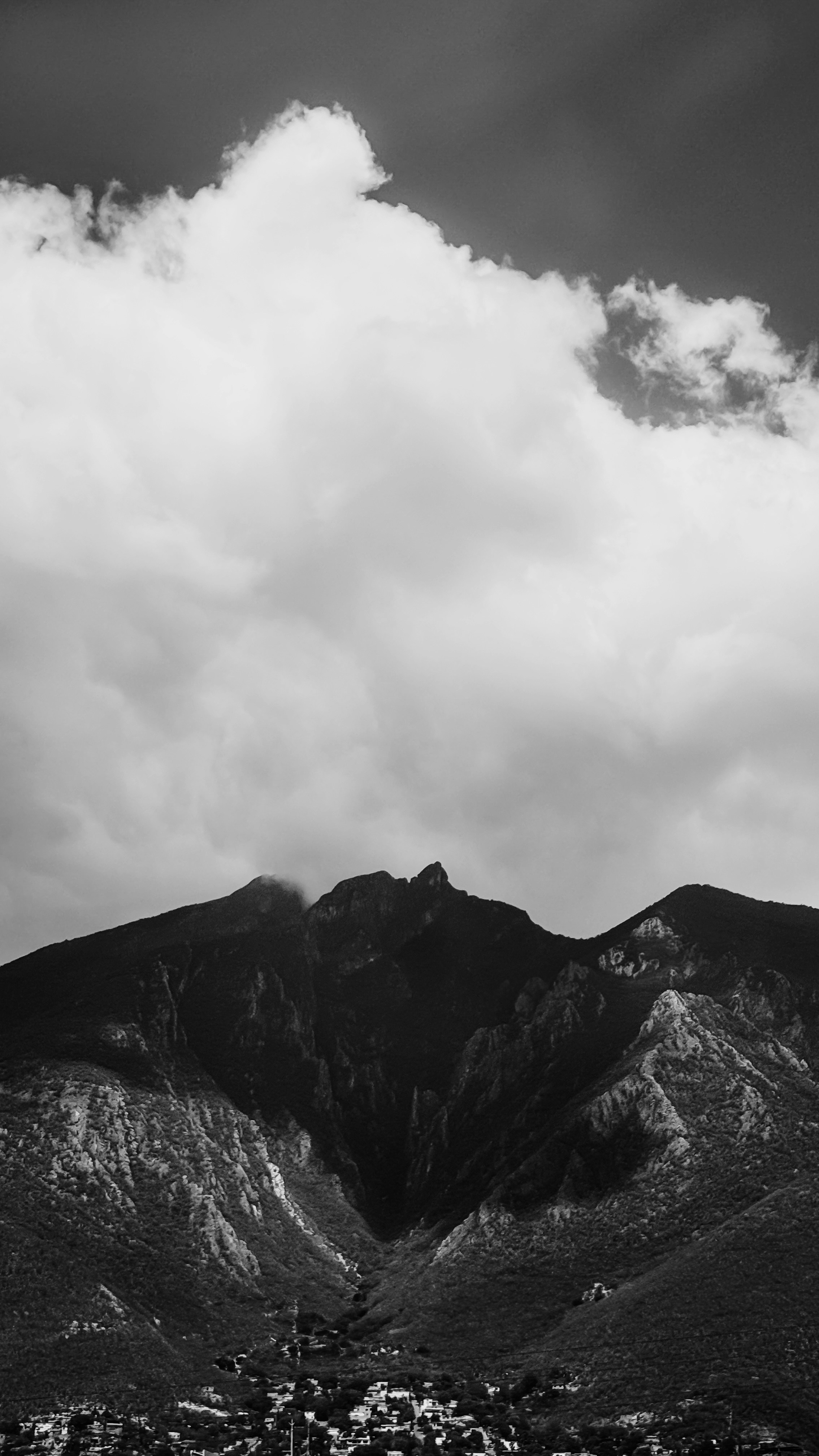 Mountains loom under a cloudy sky.