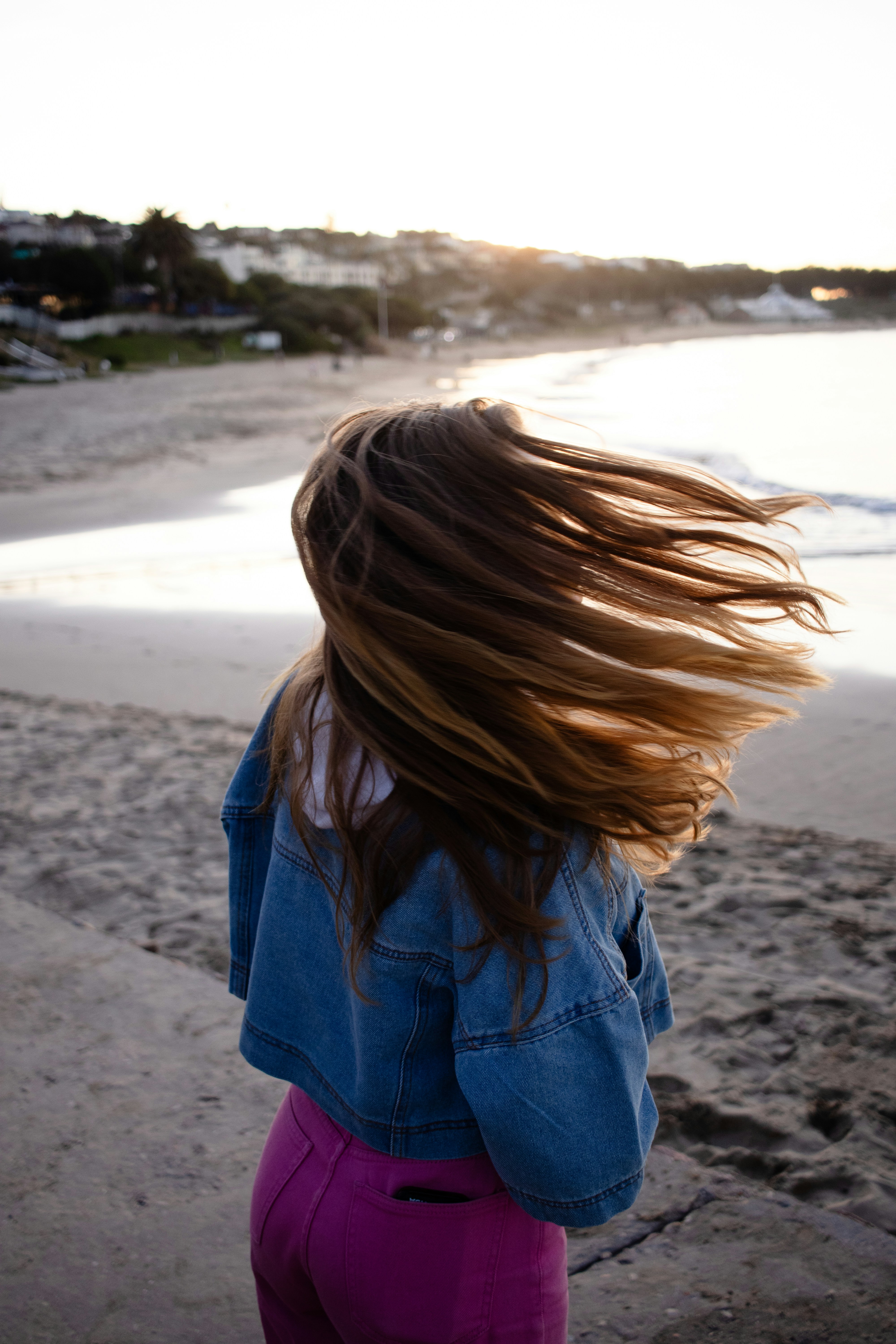 Dusk on the Strand: Wind-Tossed Hair and Denim in Sunset