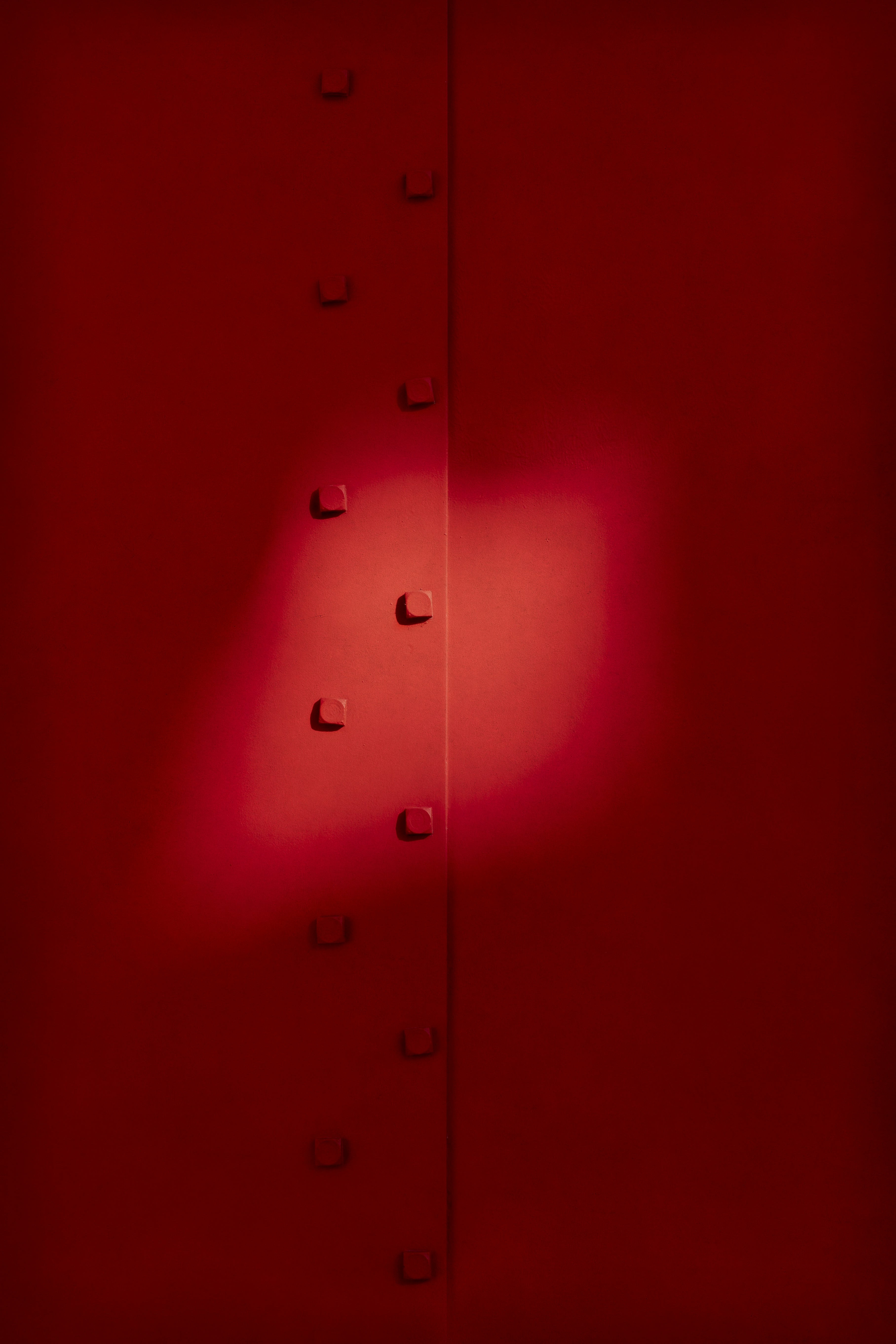 Crimson Glow Between Rivets on a Seamed Panel