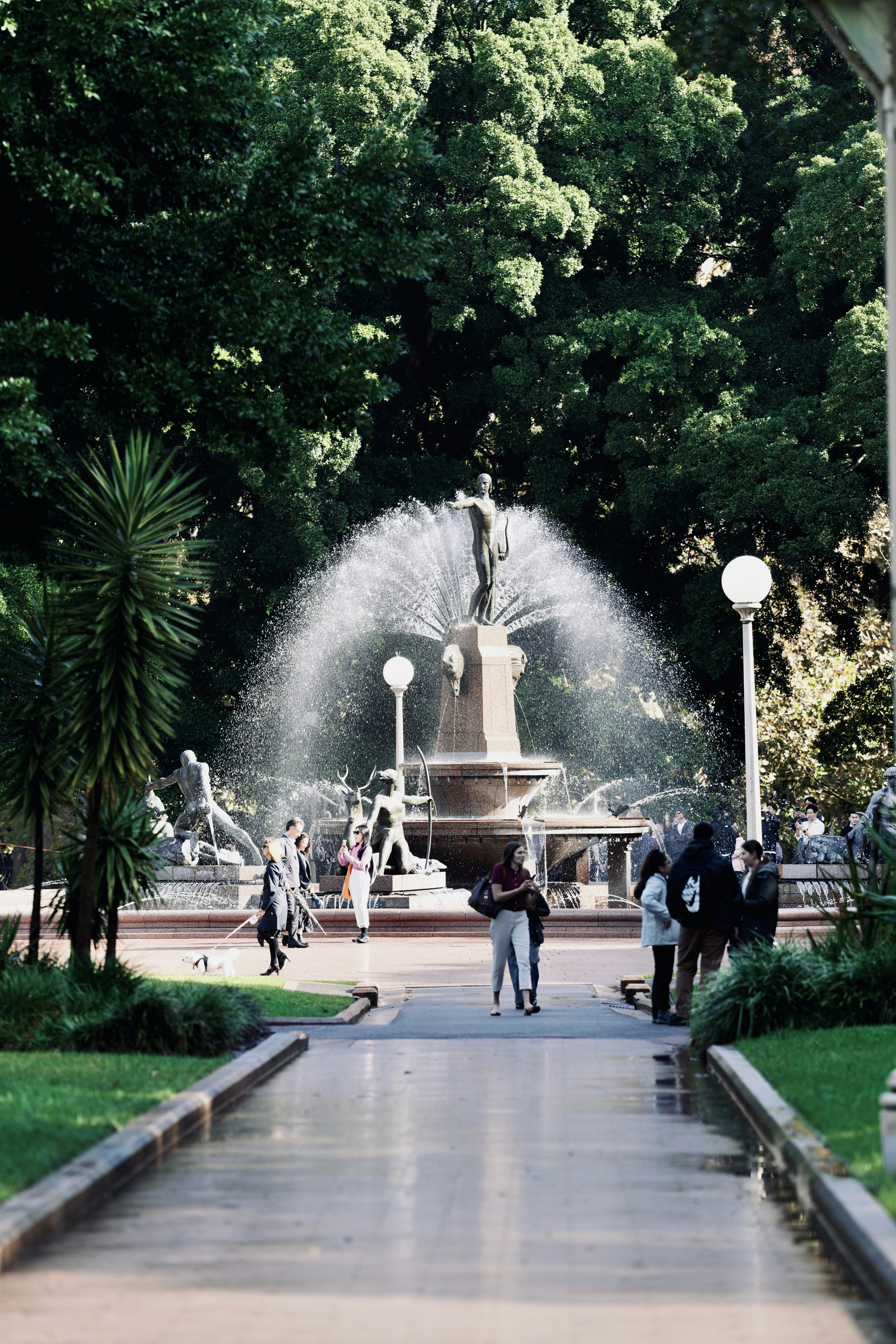 People enjoy a fountain and park.