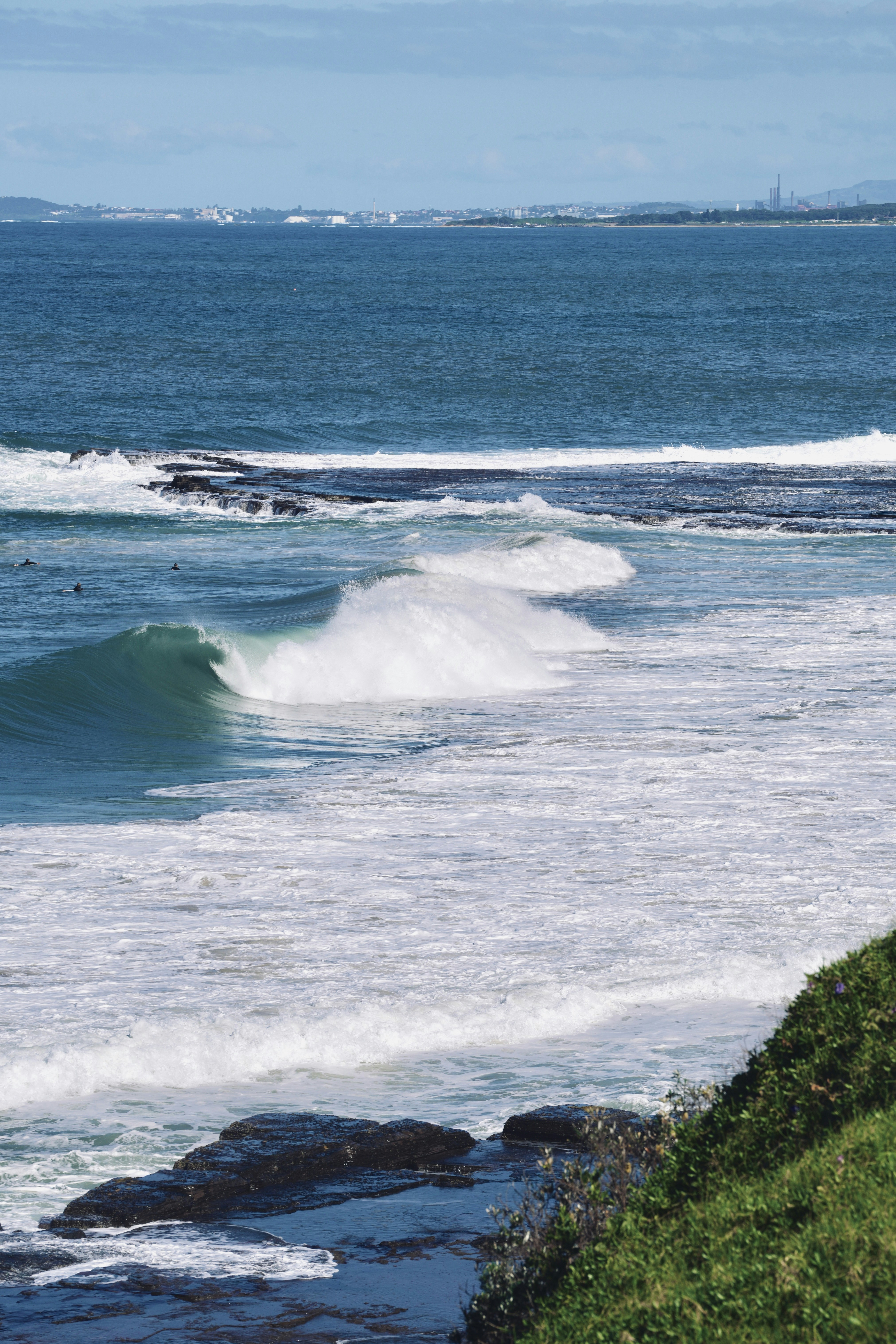 Waves crash on a rocky shore by the ocean.