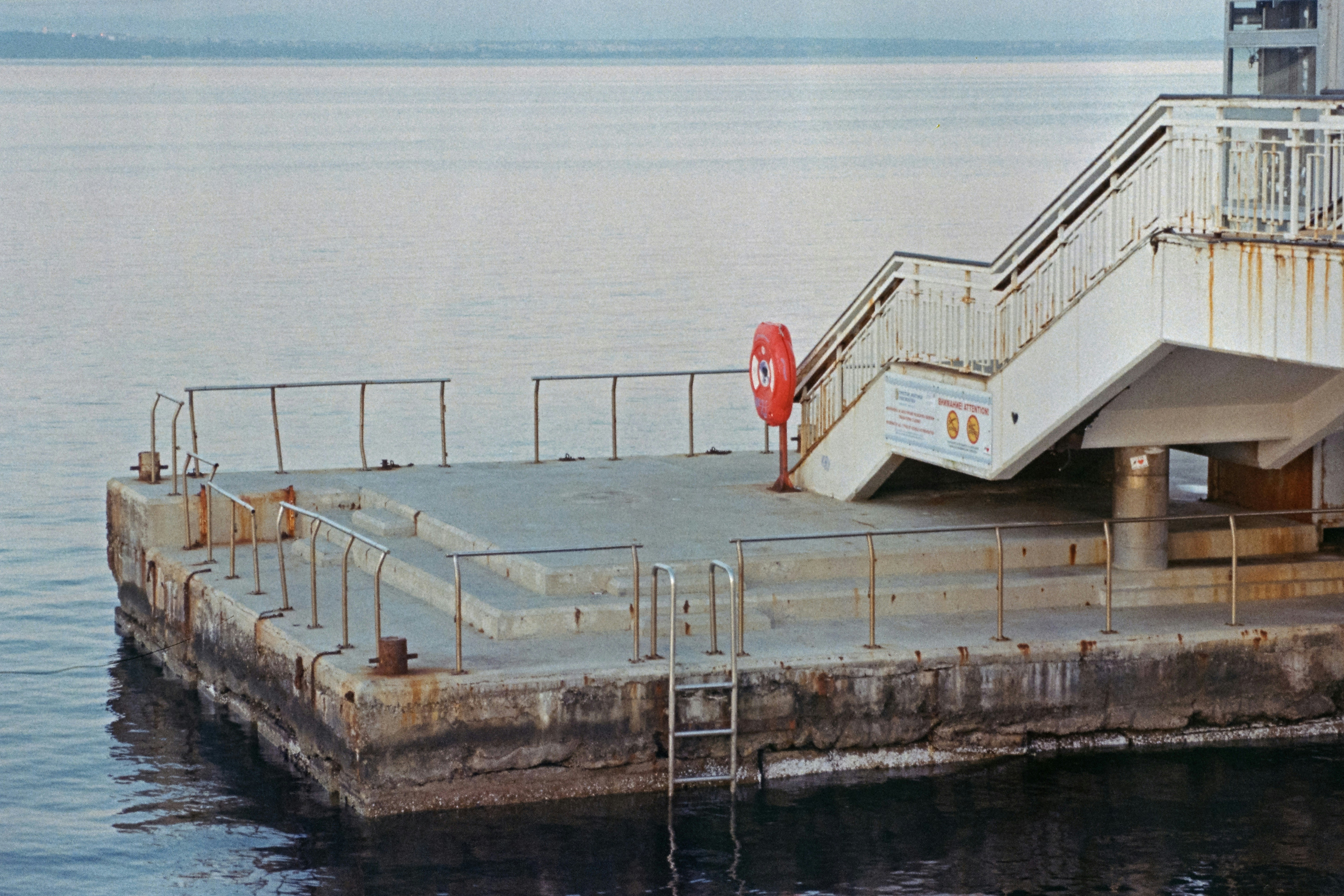 A concrete dock with stairs and life preserver. photo – Free Sea Image ...
