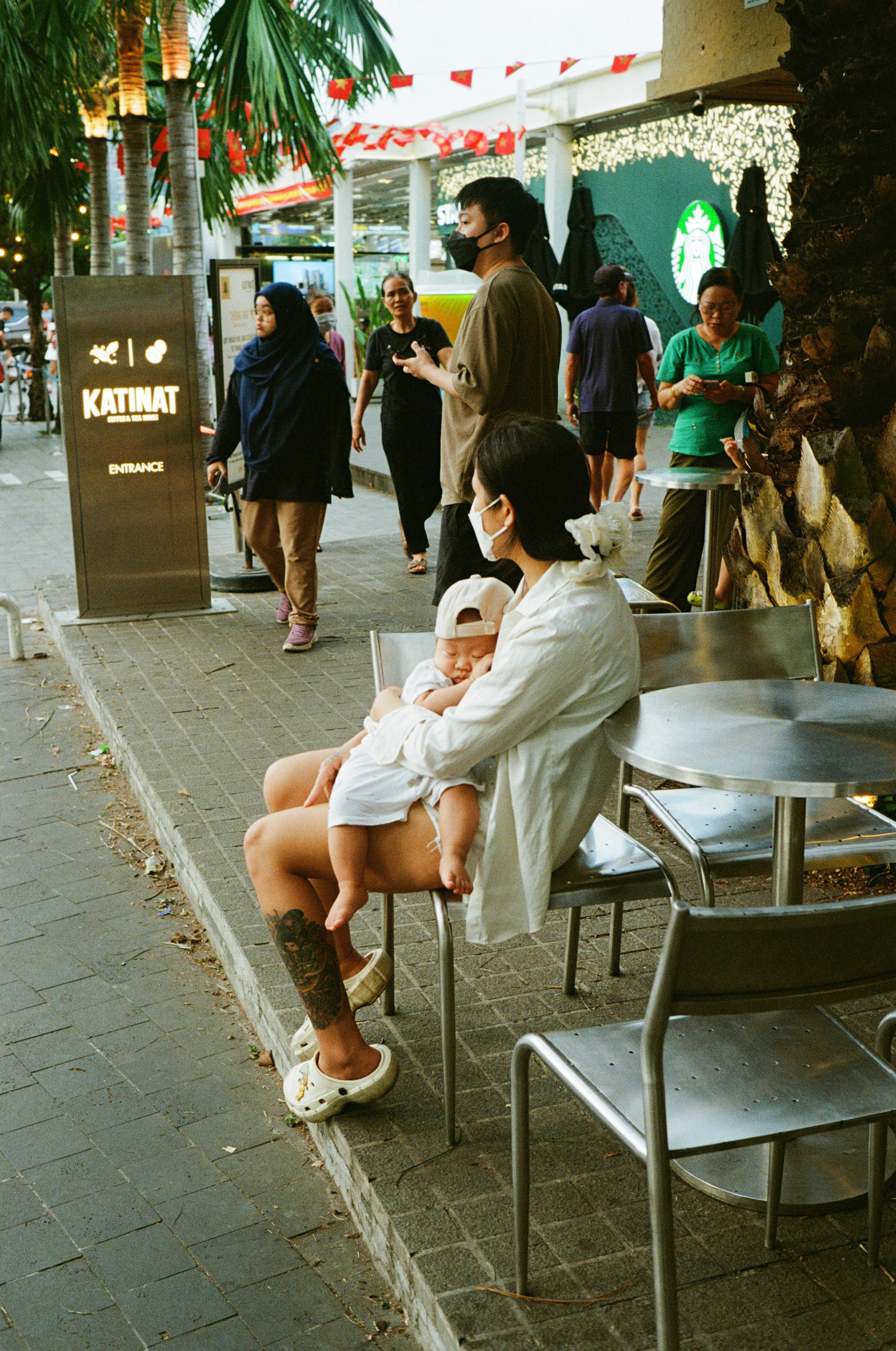 A woman and baby sit outside a shop. photo – Free Woman Image on Unsplash