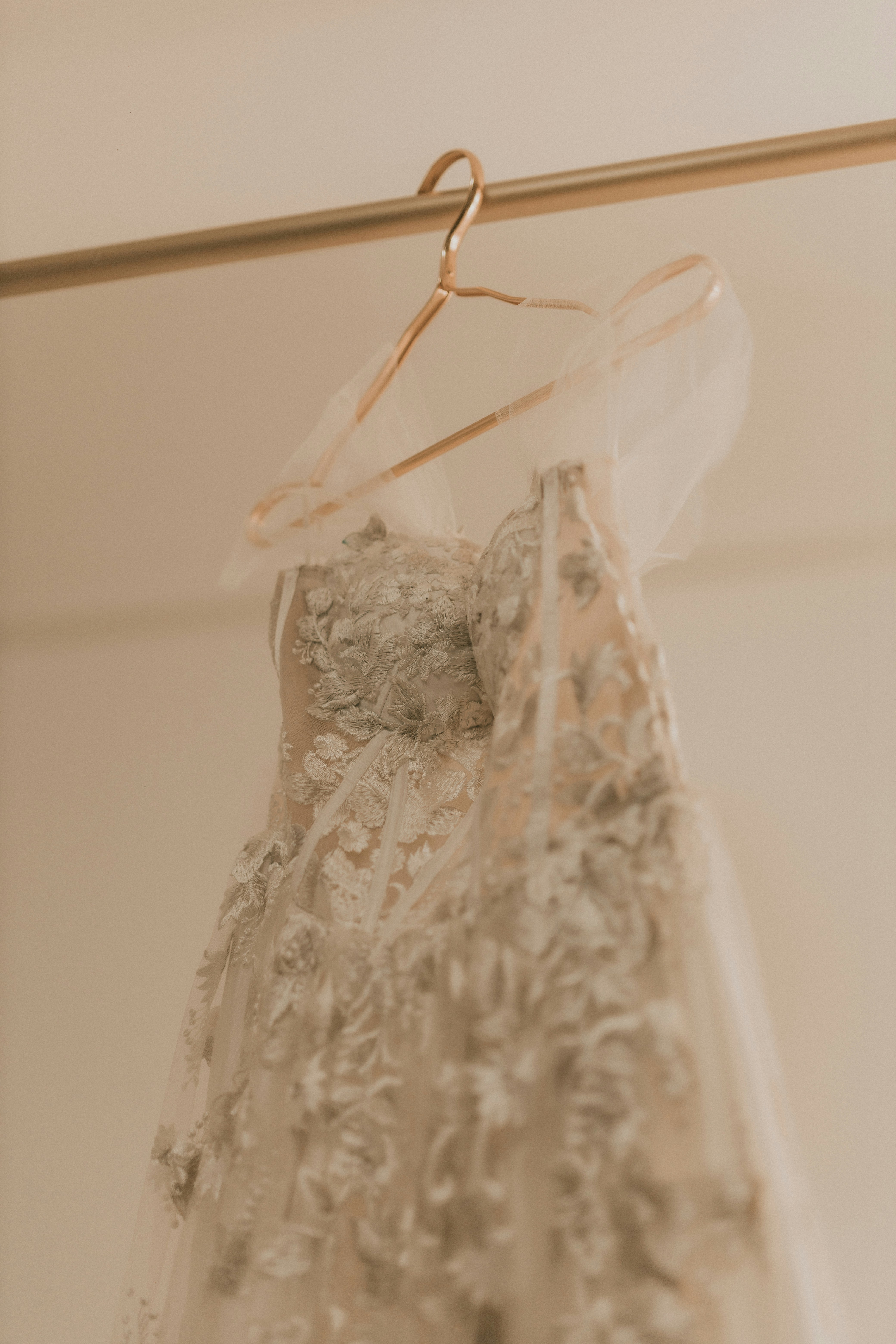 A beautiful wedding dress hangs on a golden rod. photo – Free Fashion ...
