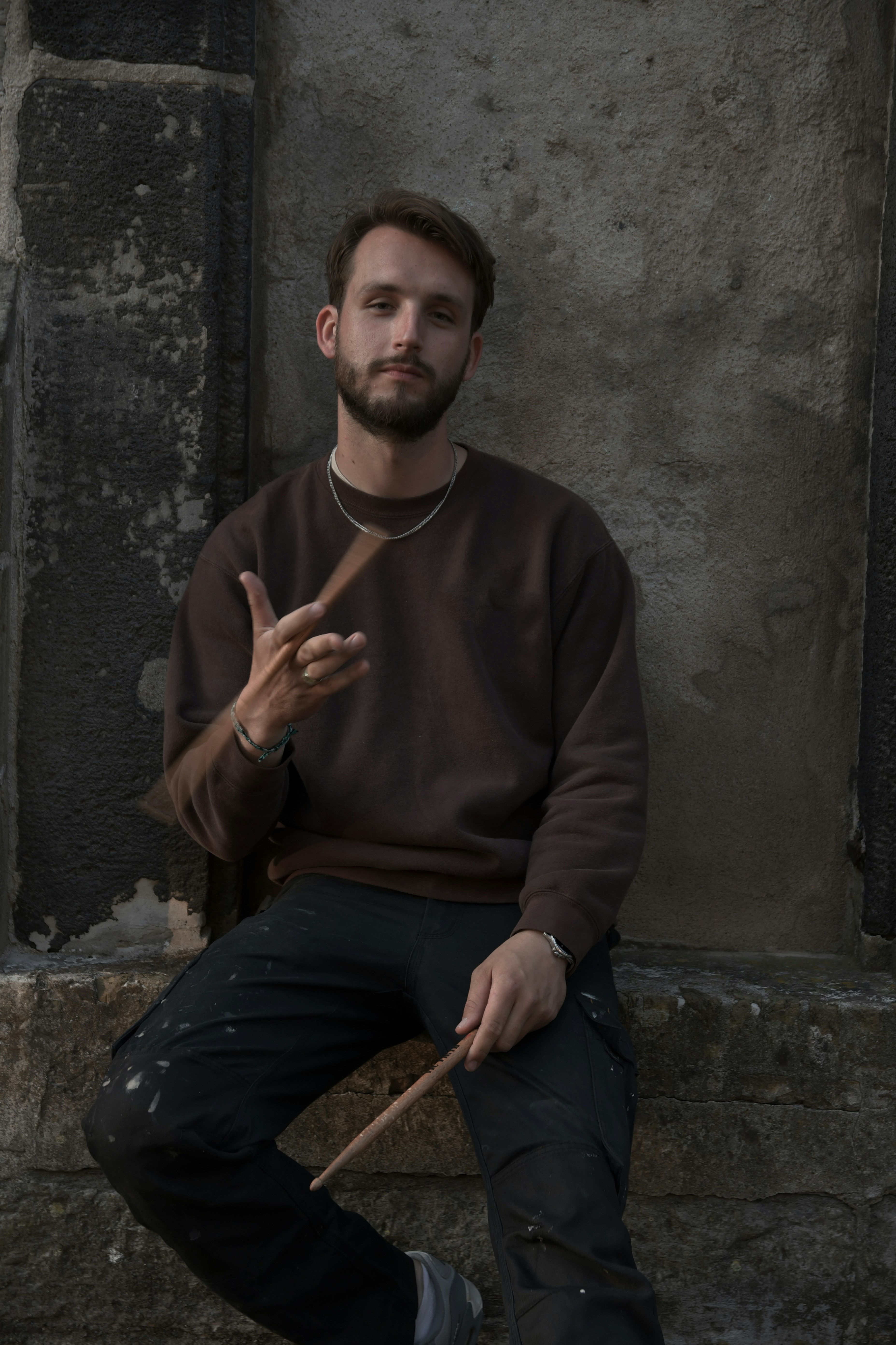 Stone-Side Gaze: A Quiet Portrait Against Weathered Walls