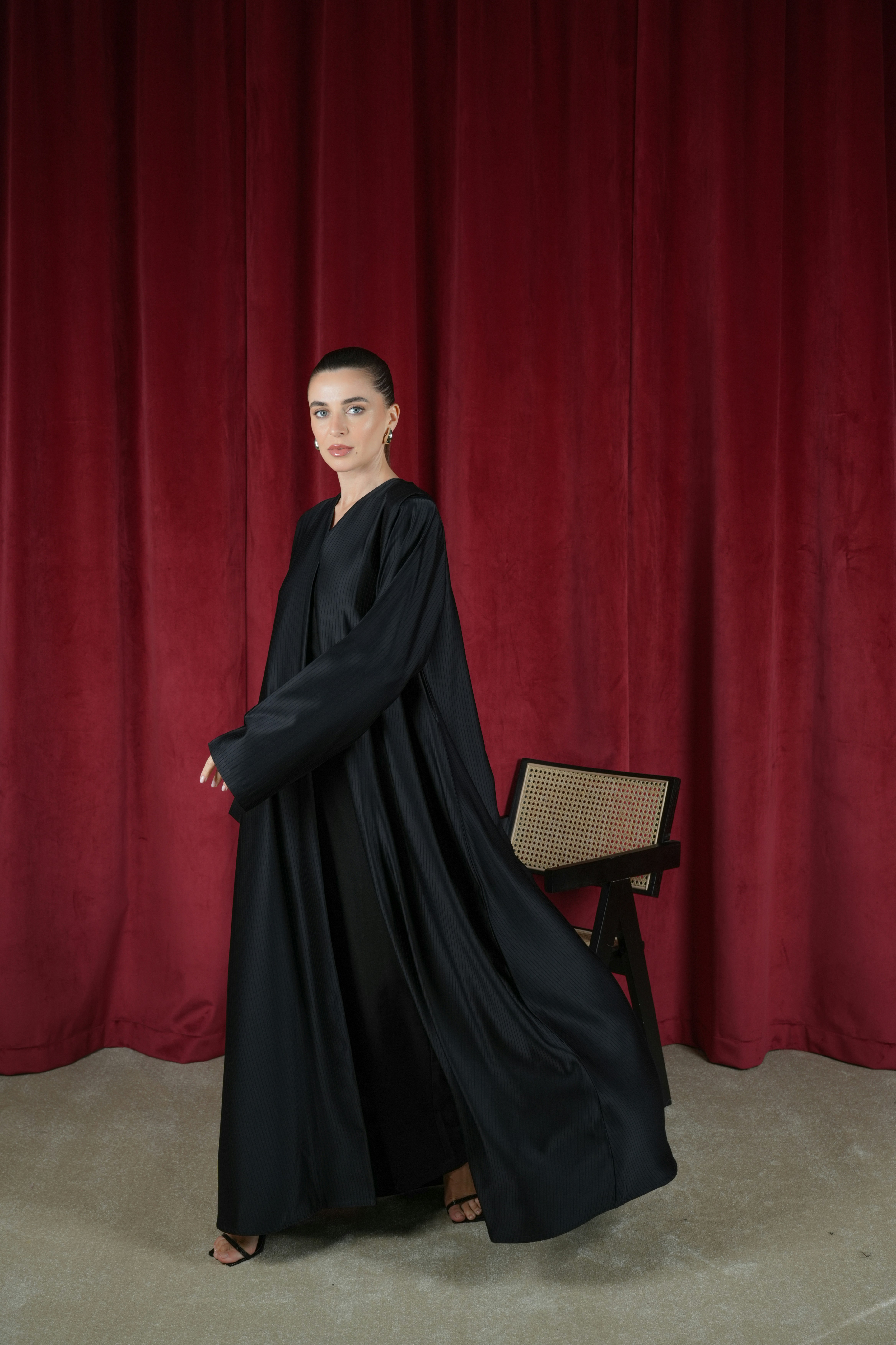 Crimson Velvet Backdrop, Silent Poise: Portrait in a Flowing Black Gown