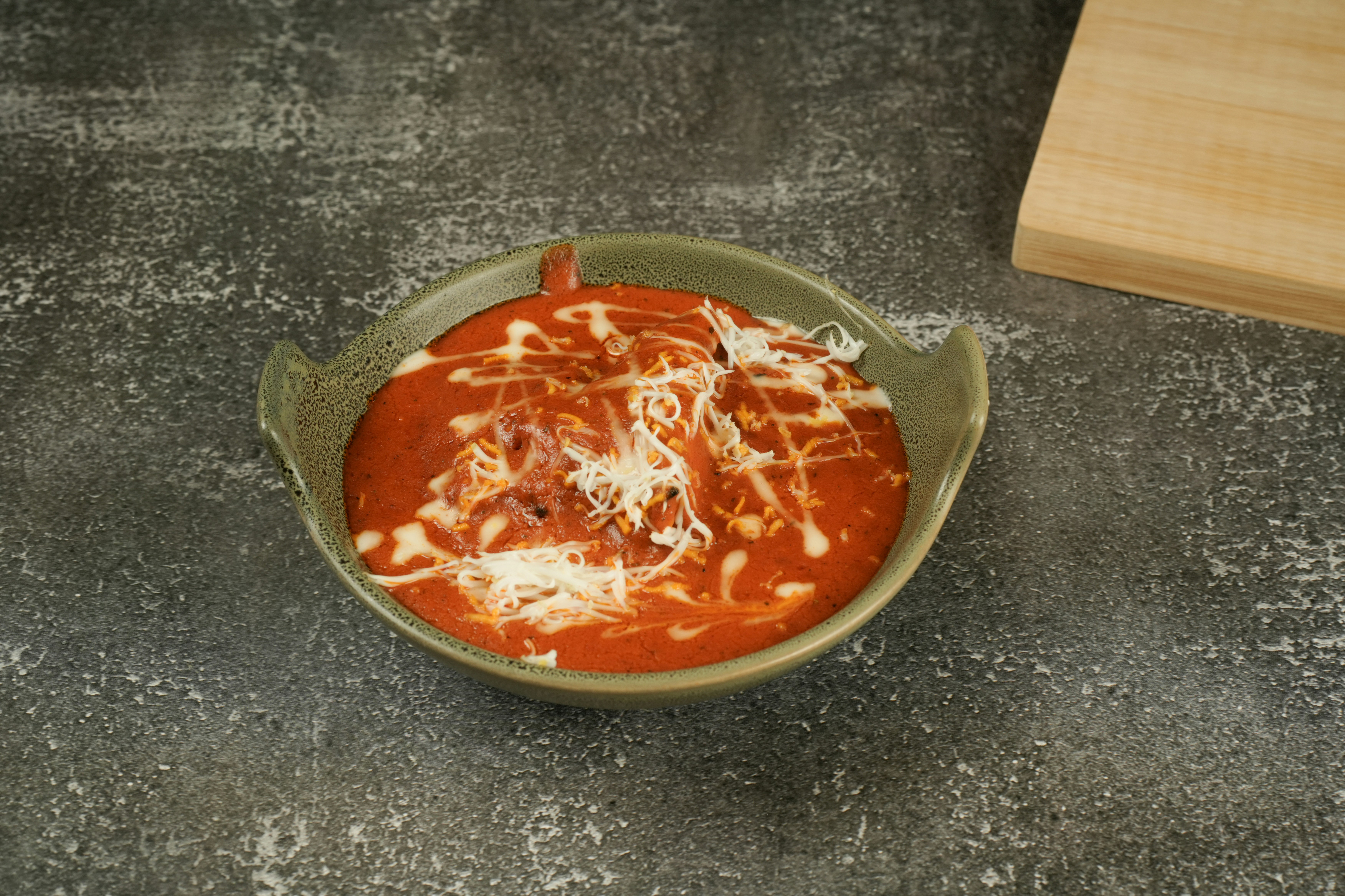 Tomato soup with cheese in a bowl.
