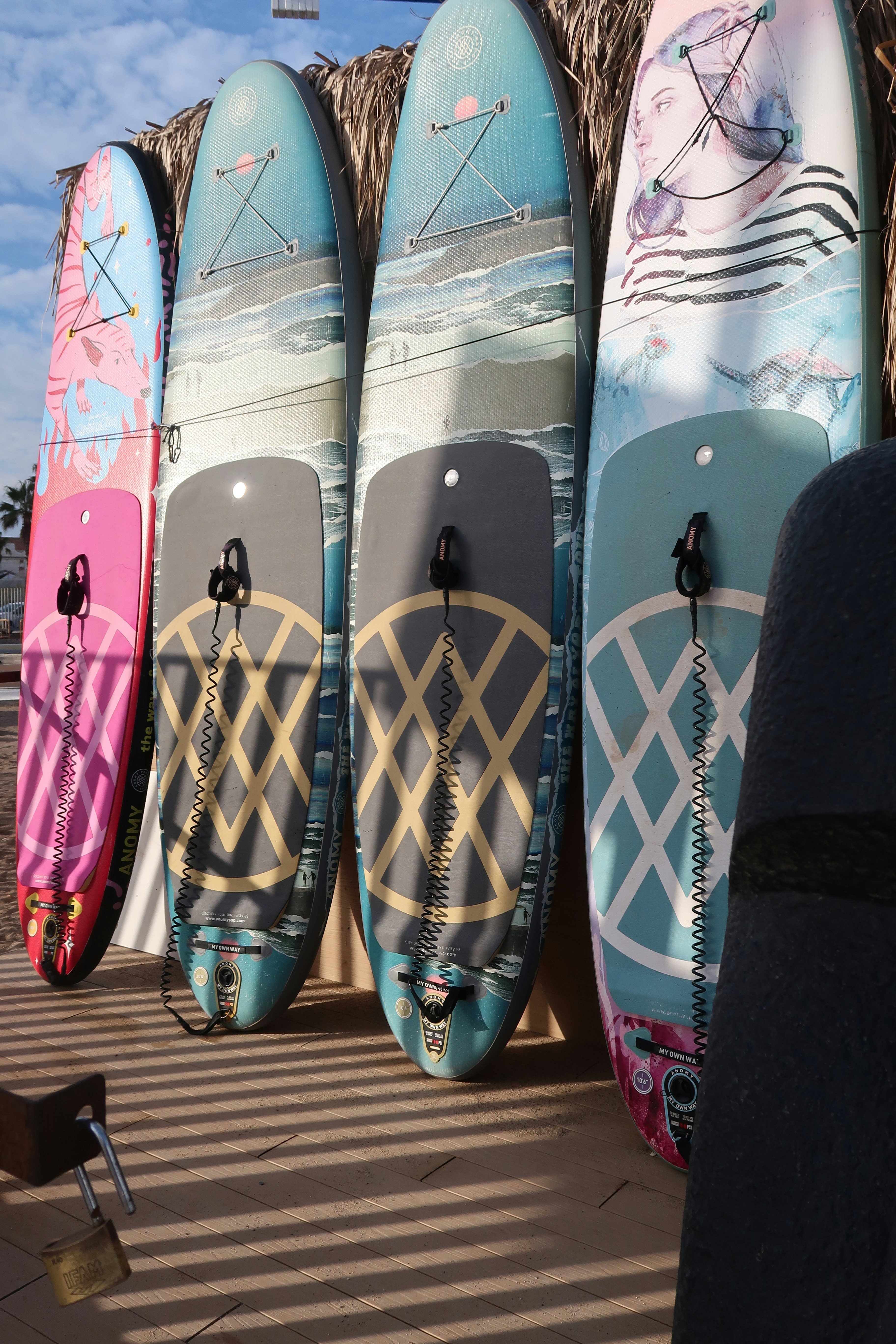 Colorful paddle boards lean against a structure. photo – Free Beach ...