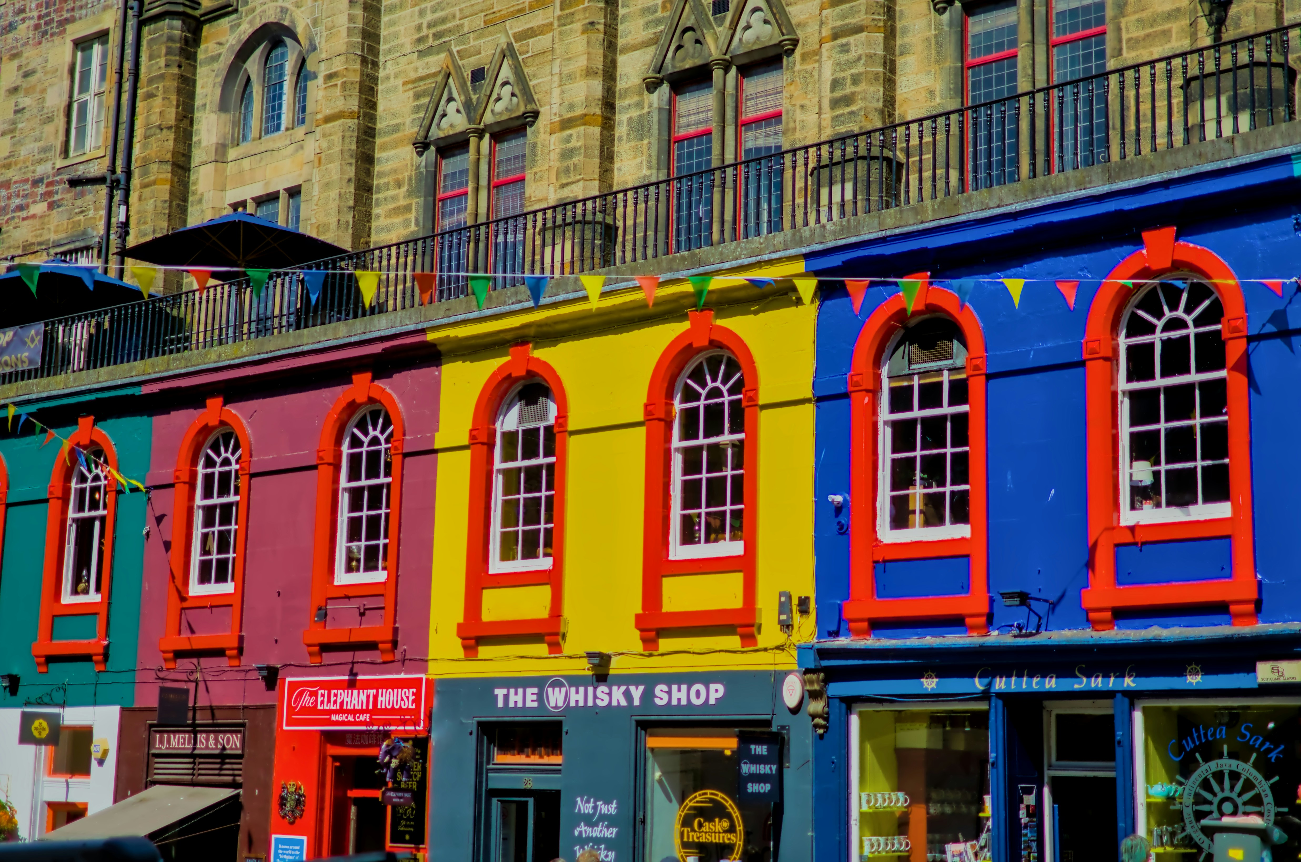 Colorful buildings line a street in edinburgh.