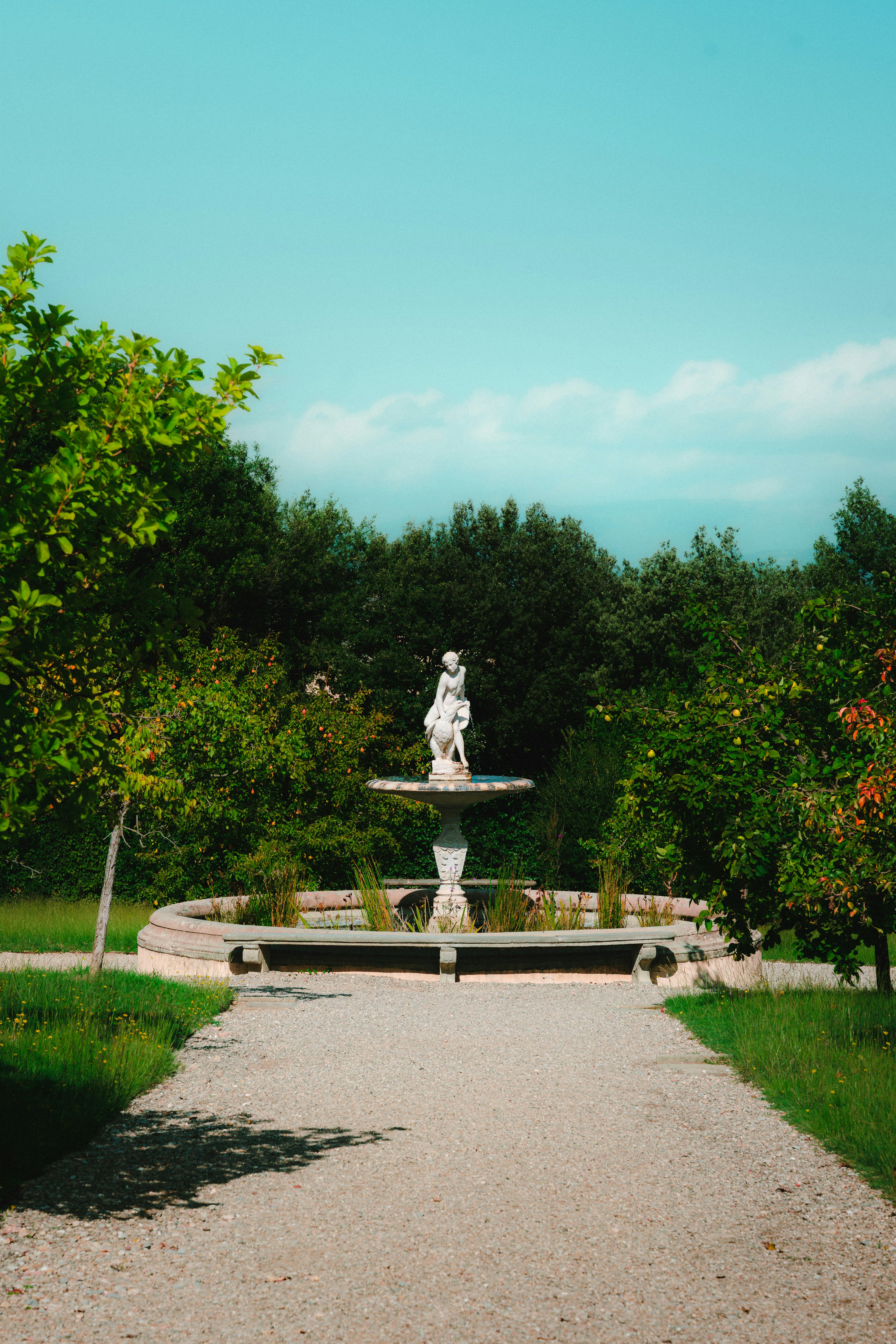 Boboli Gardens statue | A serene garden path leads to a fountain.