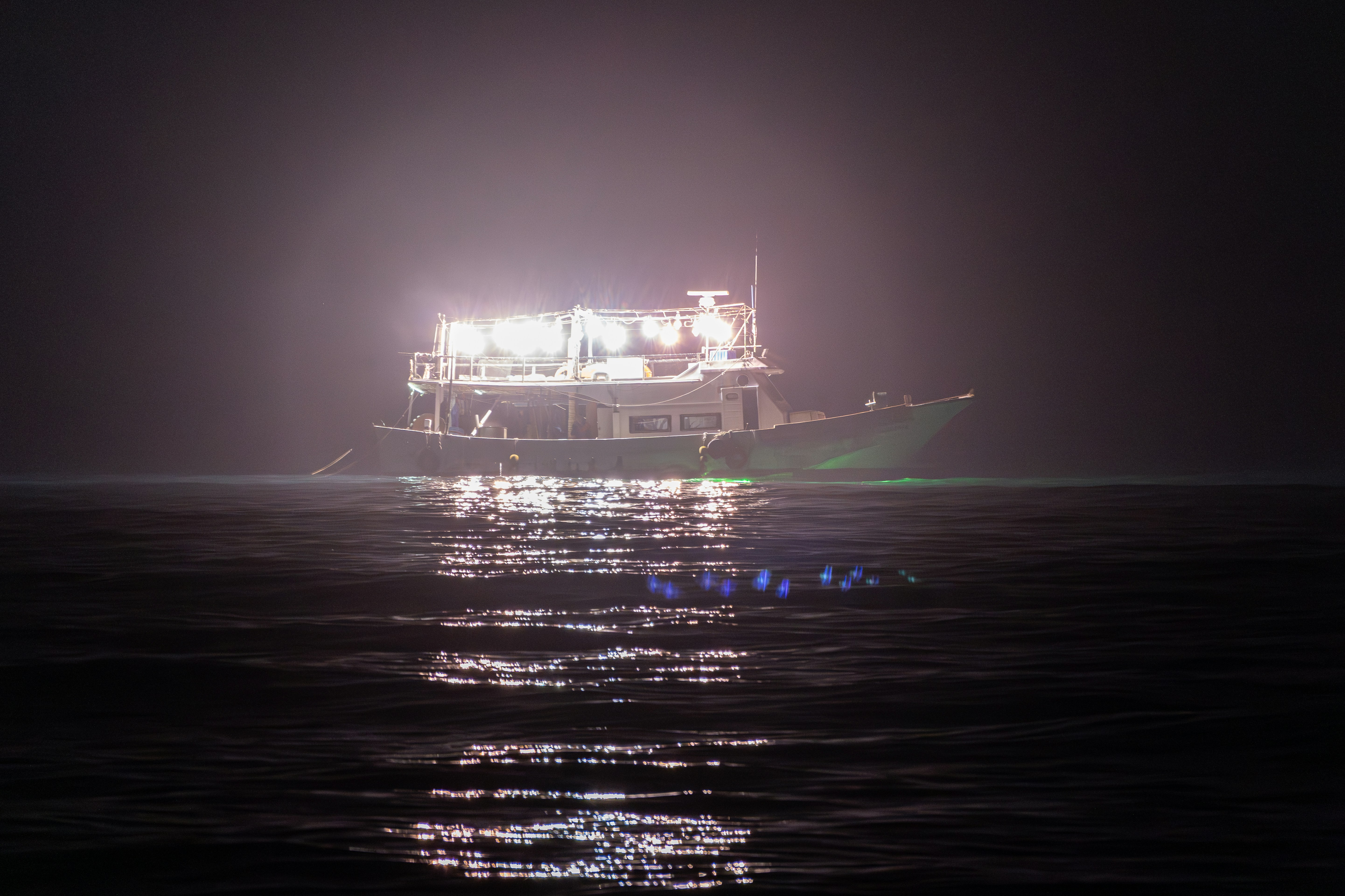 A boat shines its lights at night. photo – Free Sea Image on Unsplash