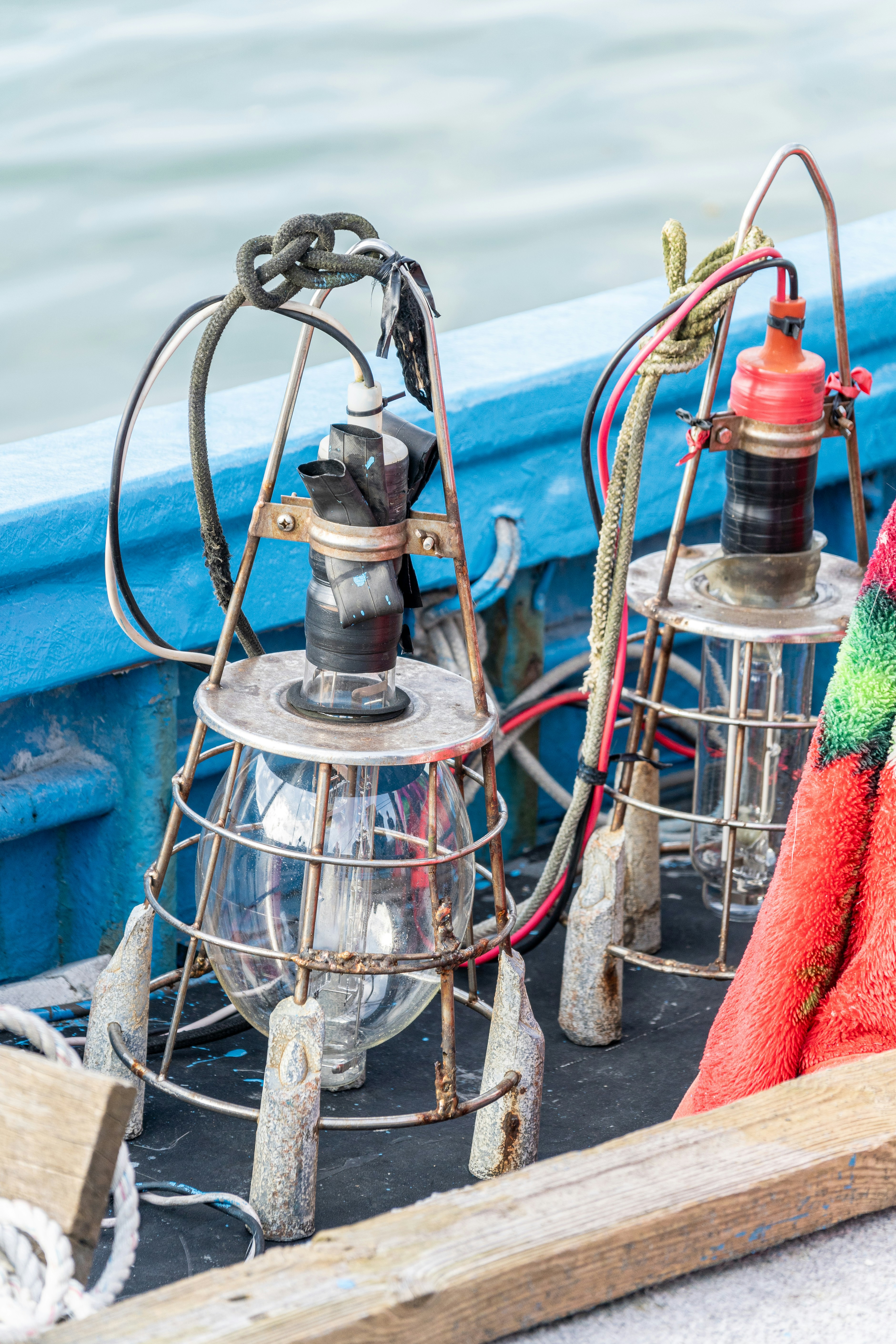 Guardians of the Blue Hull: Two Rusted Lanterns on a Weathered Deck
