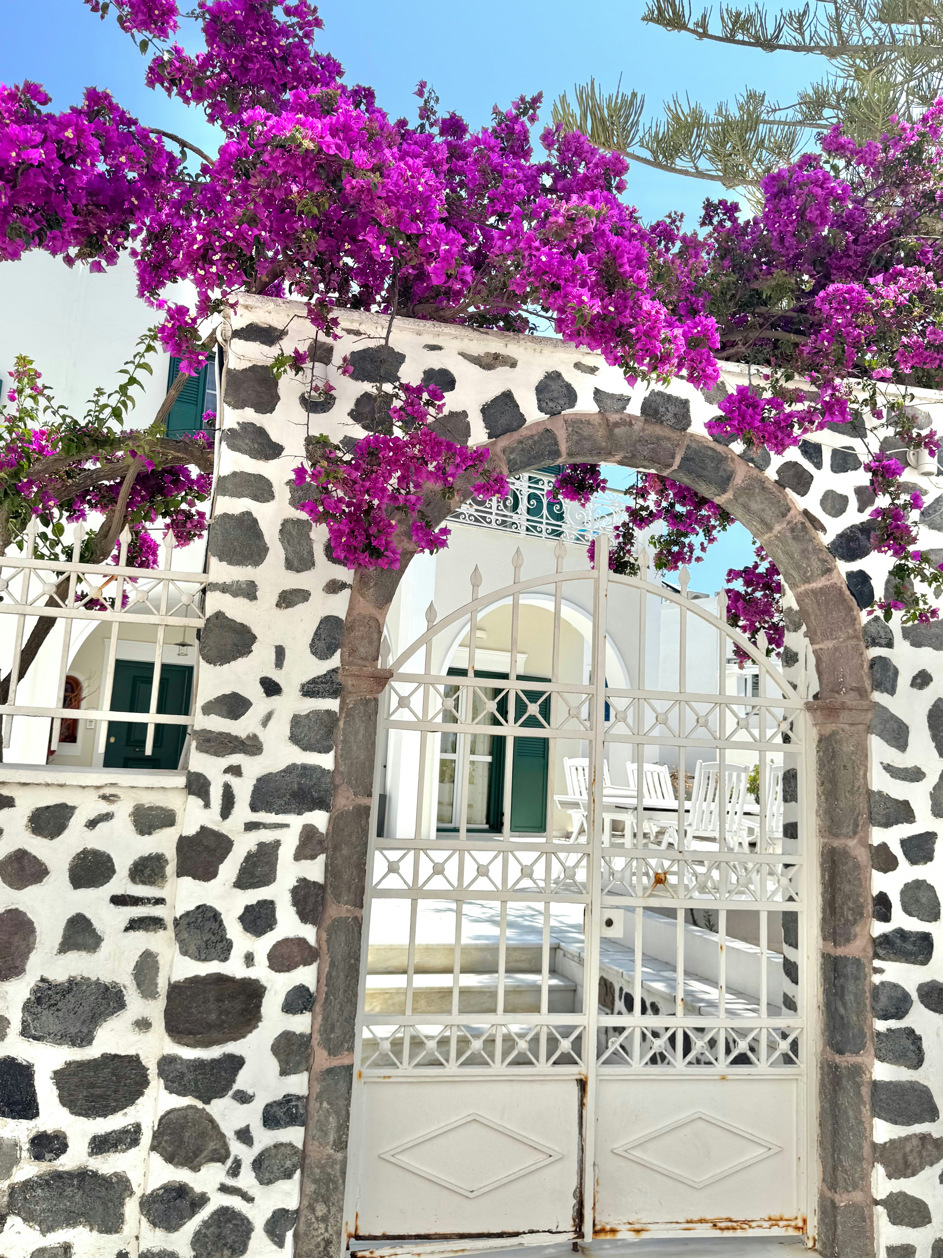 Ivory Archway Framed by Bougainvillea in a Stone Courtyard