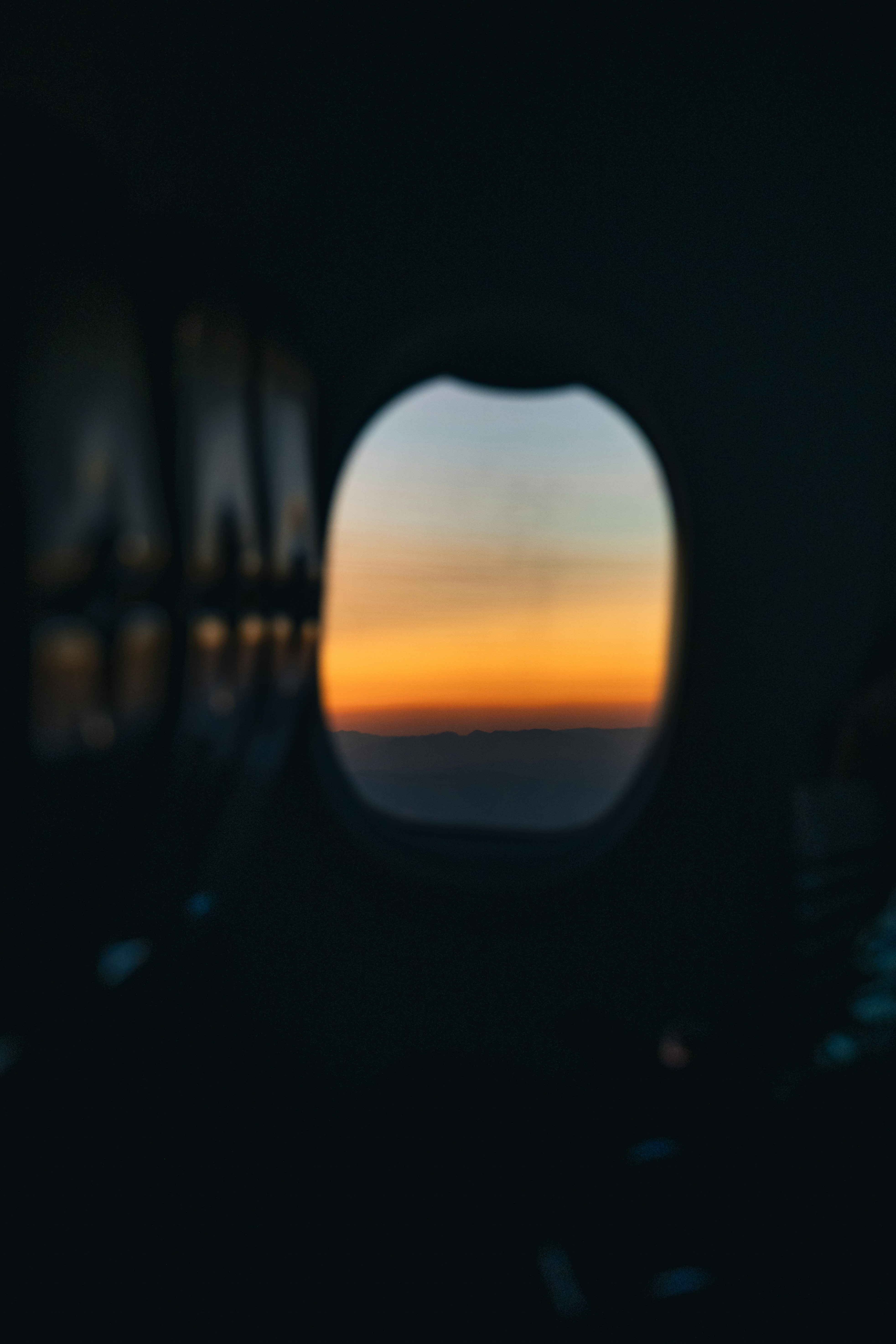 Sunset is seen through an airplane window.