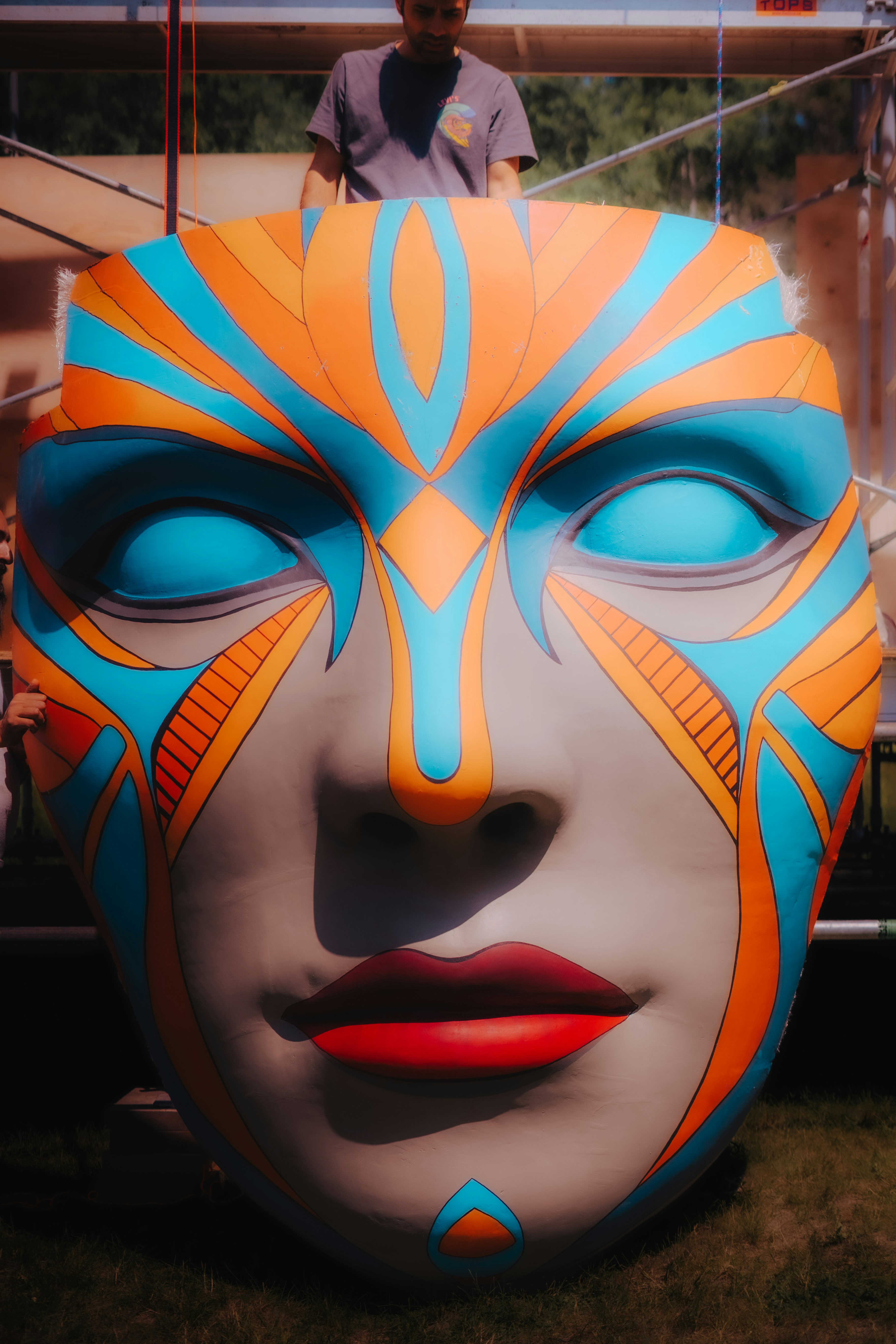 Giant mask with colorful design and features.