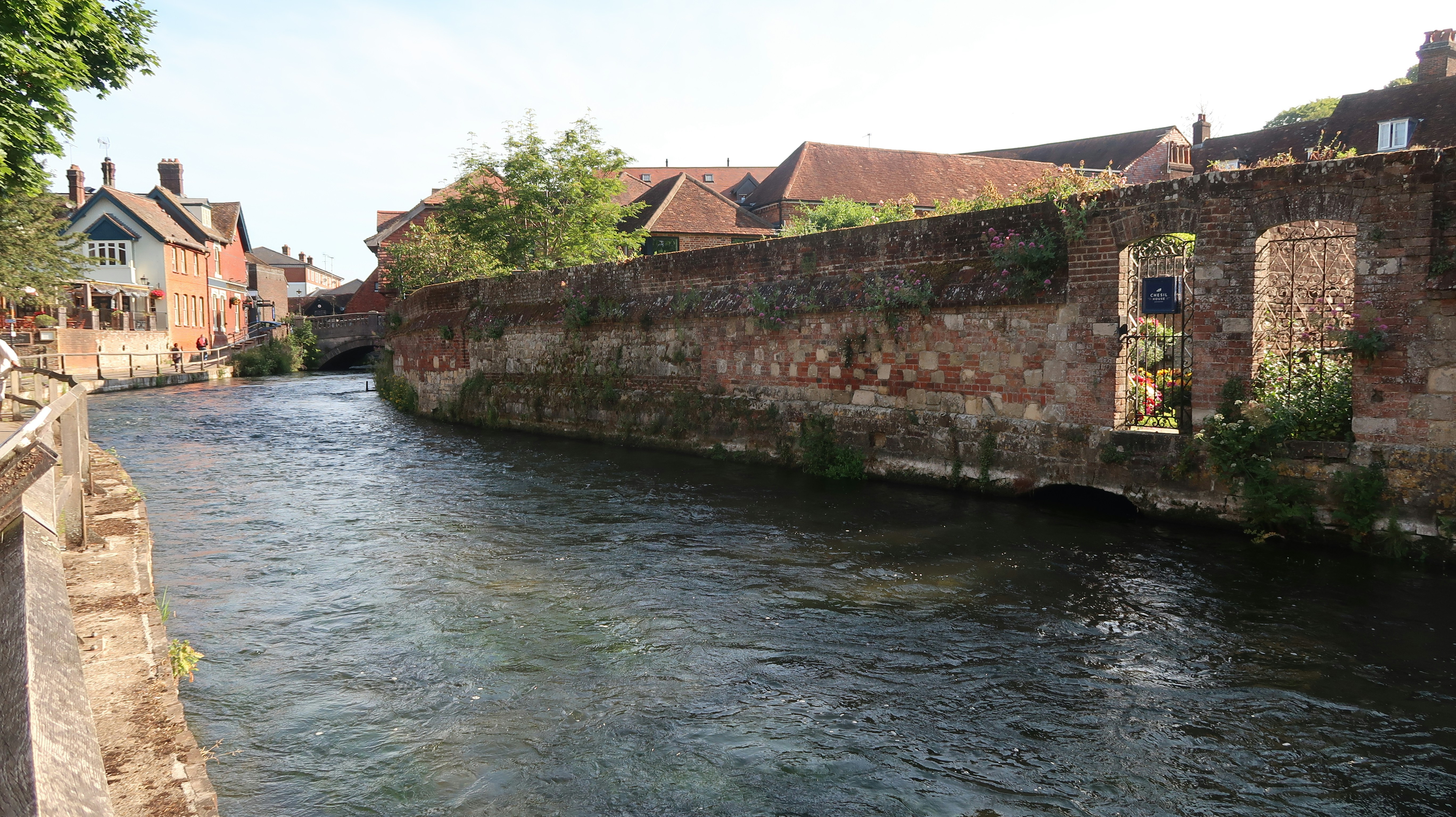 Ivy-Embraced Canal: Red-Brick Walls Framing a Quiet River