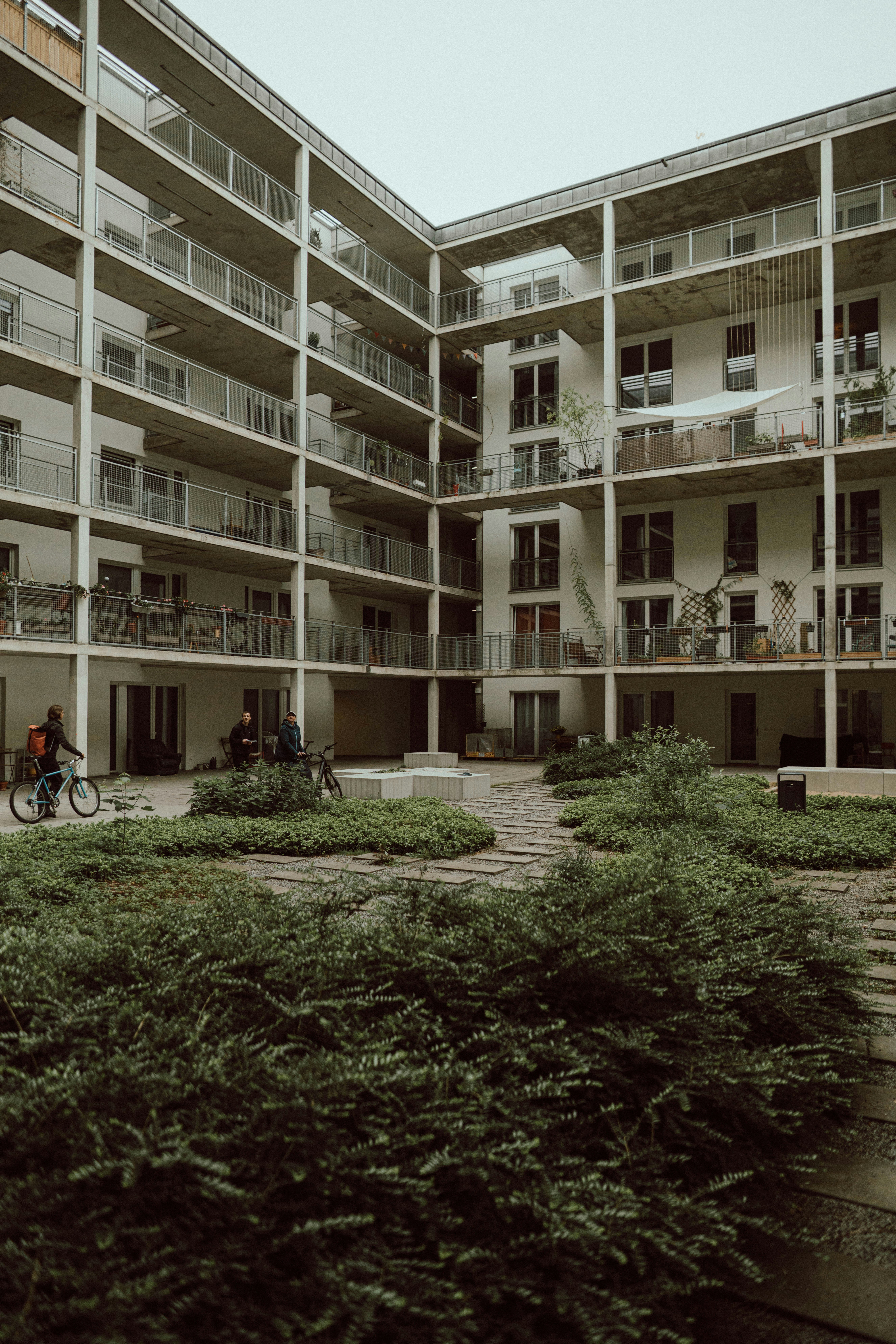 Apartment courtyard with greenery and bicycles.