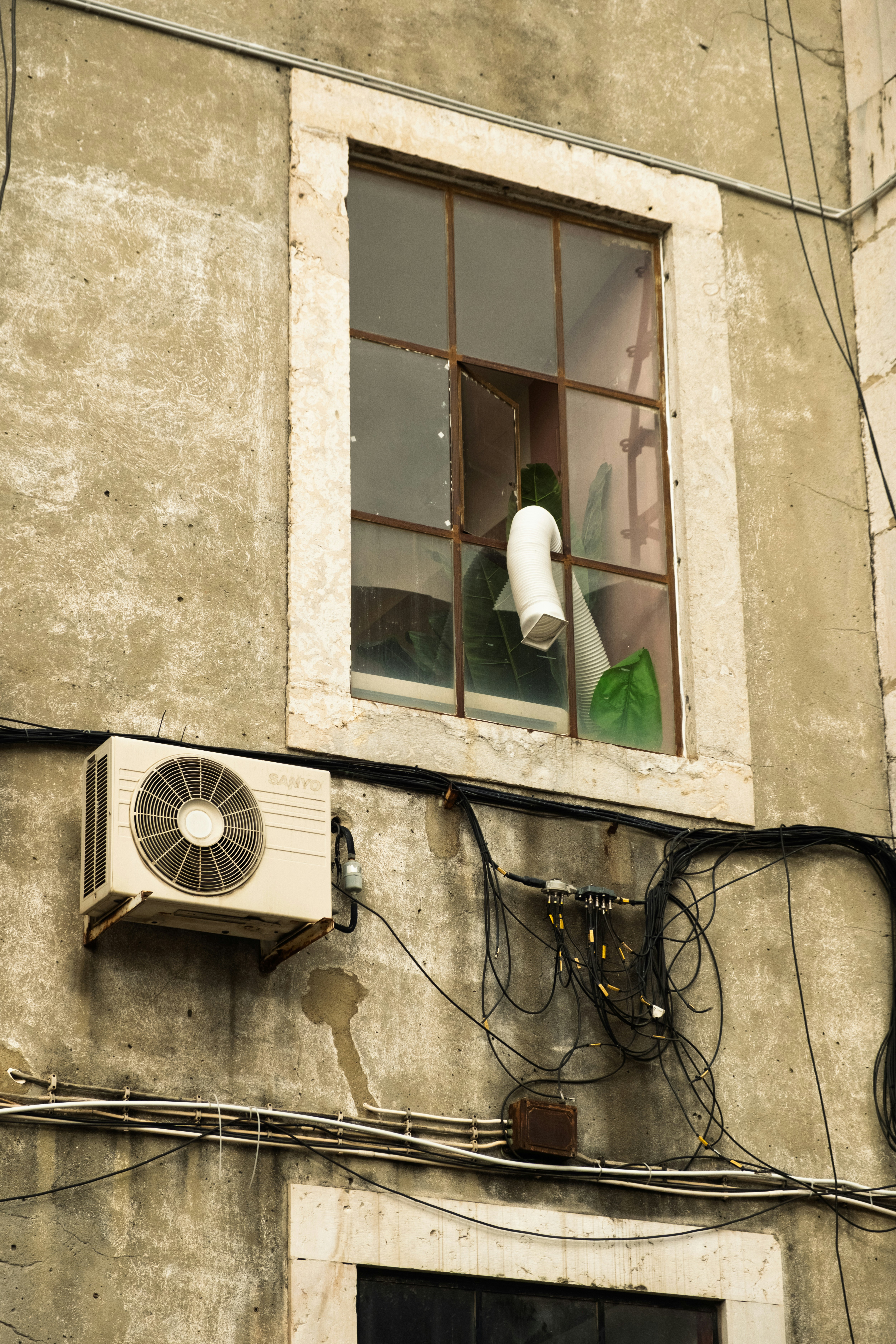 An old building with a window and air conditioner.