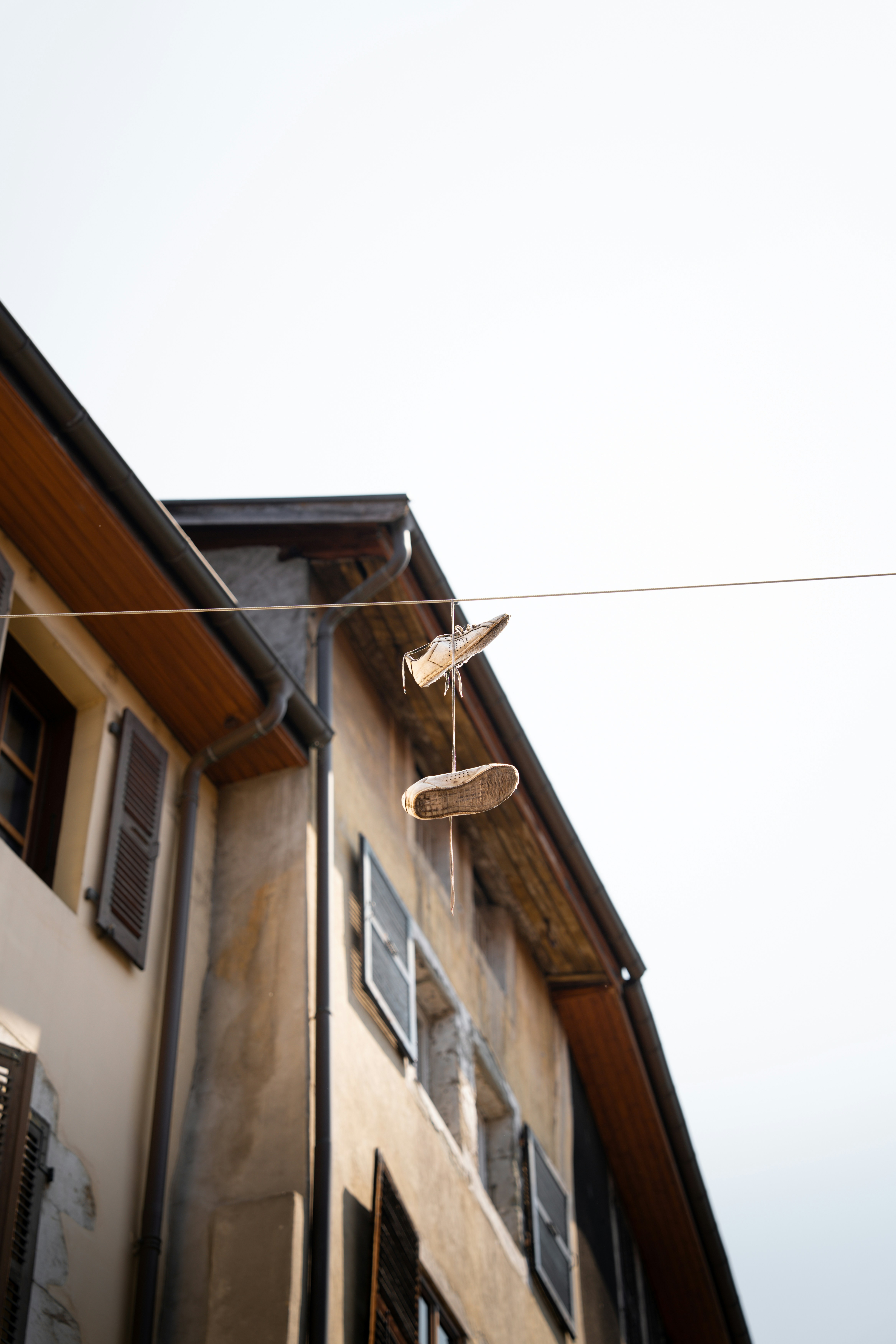 Hanging Shoes Over a Weathered Urban Facade