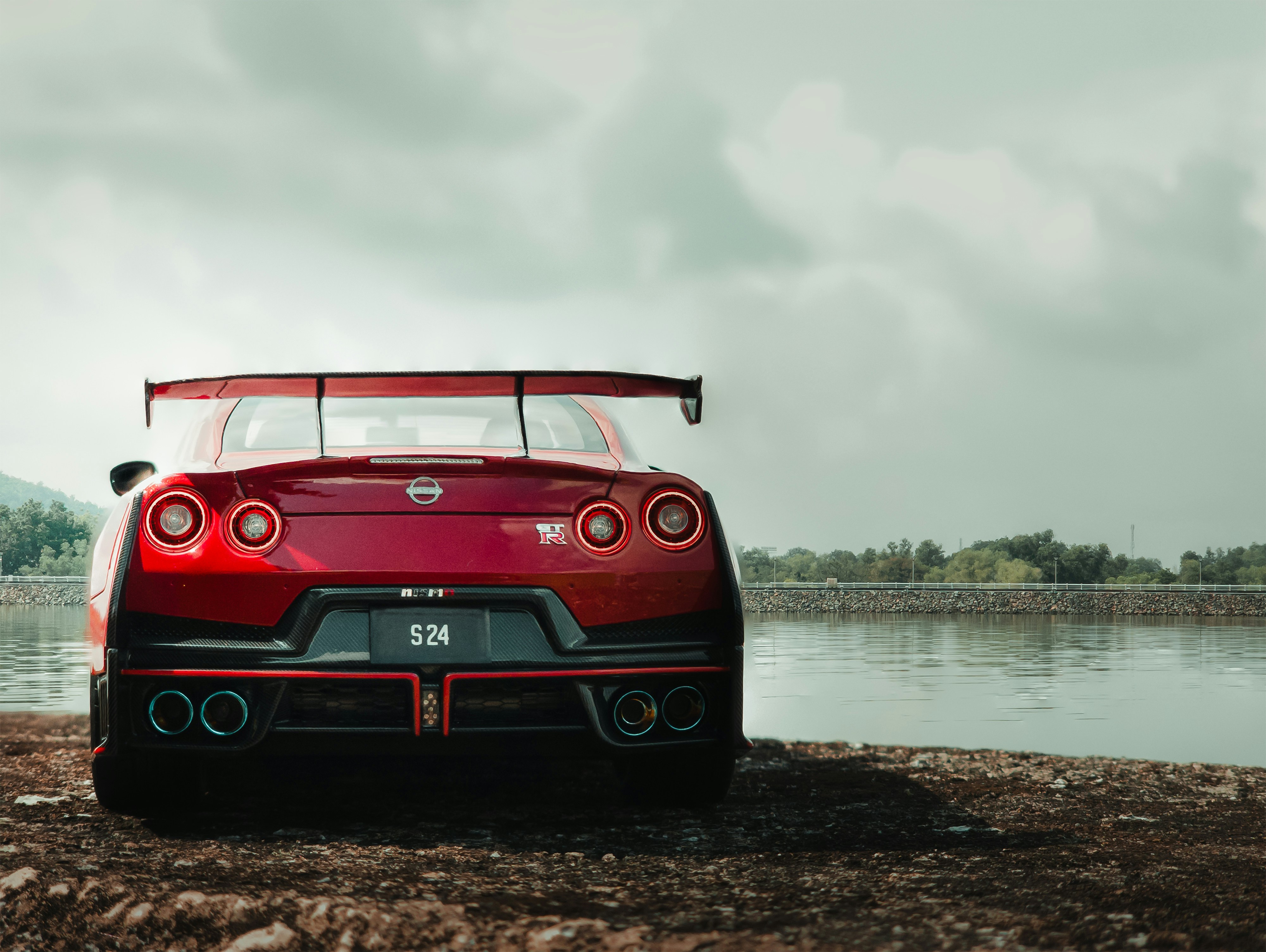 A red nissan gt-r rests by the water. photo – Free Car Image on Unsplash