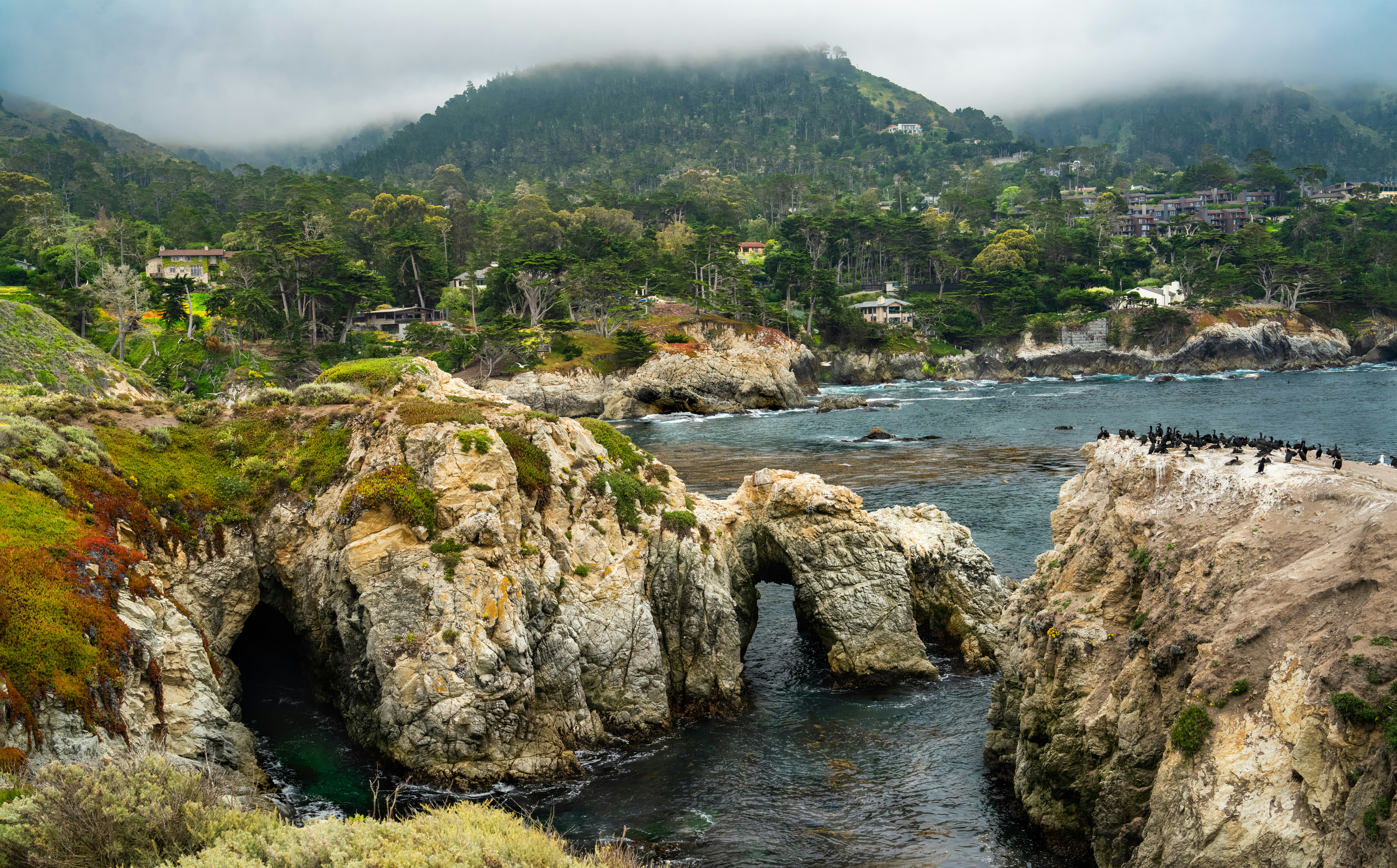 Archway of the Pacific: Weathered Stones Framing a Quiet Coastal Village