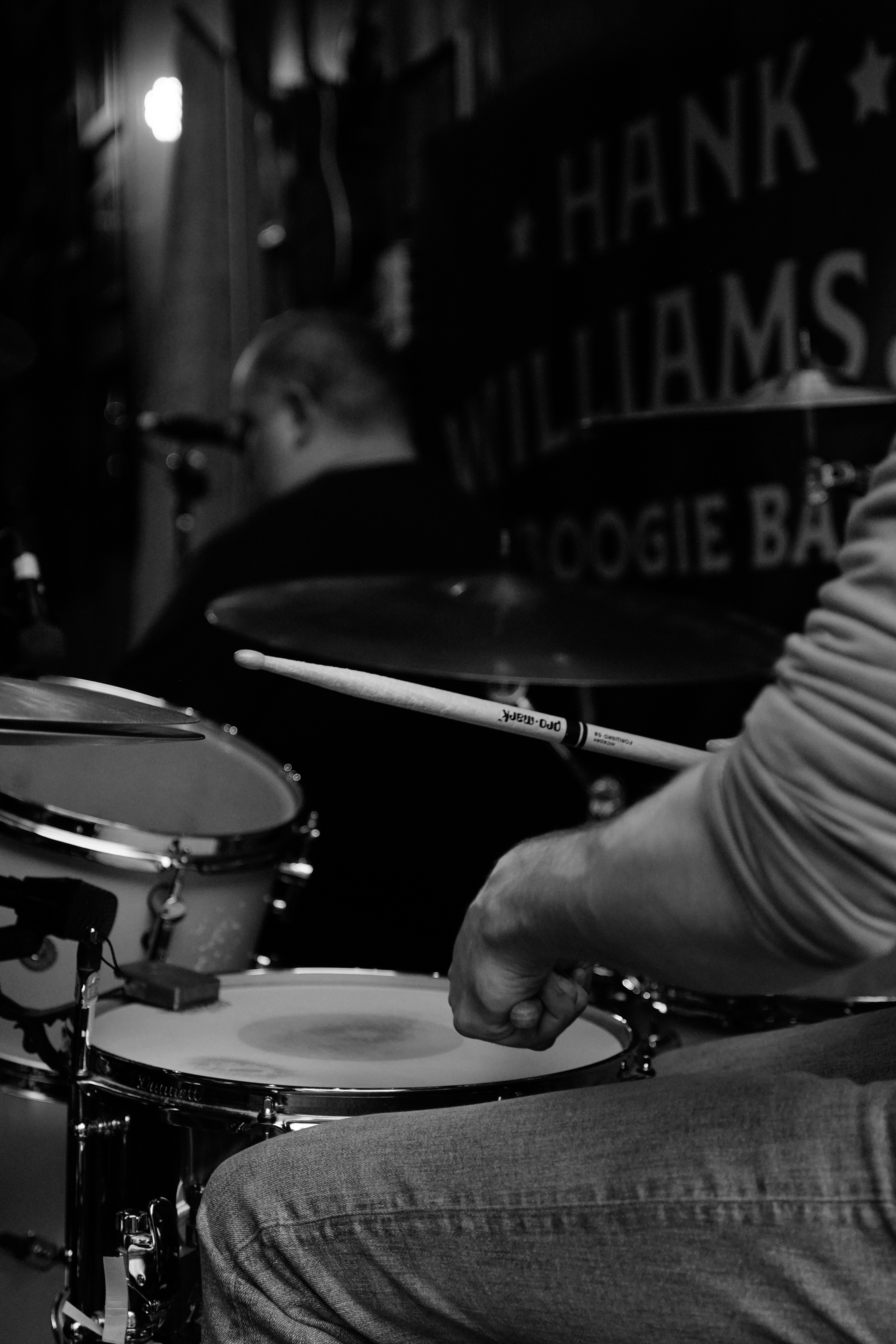 A drummer plays on stage, in black and white.