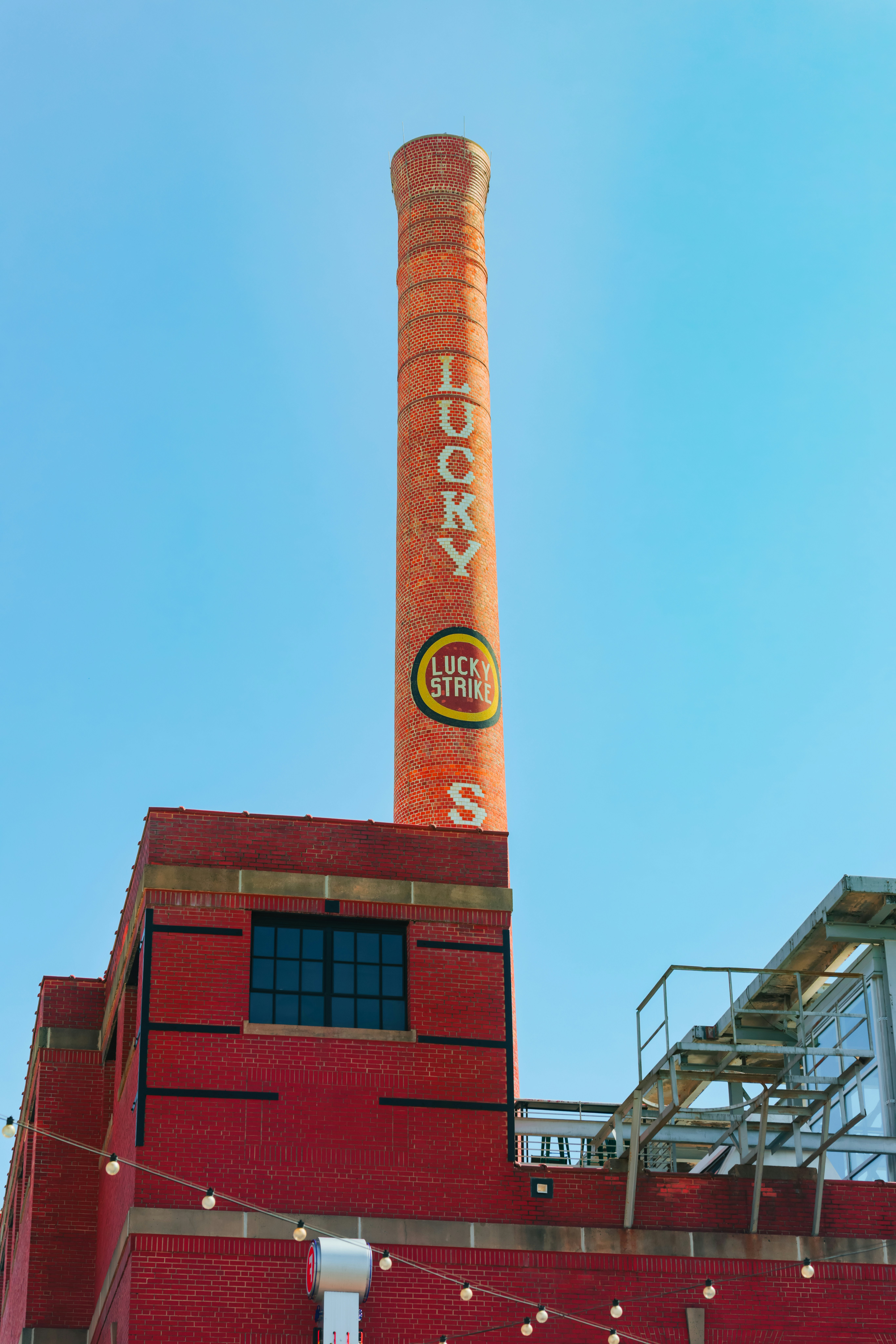 Lucky strike factory smokestack in a vibrant sky.