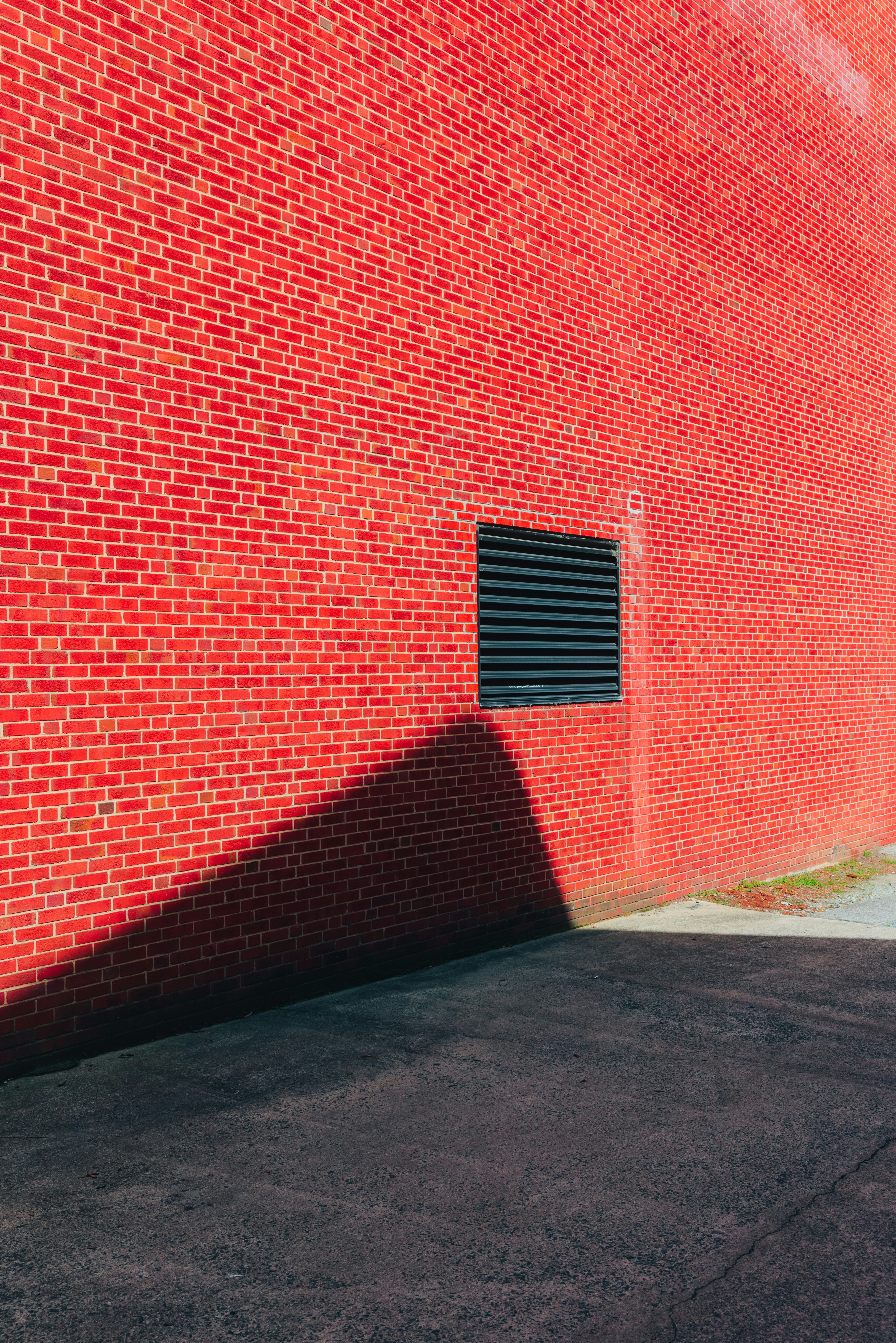 Louvered Vent on a Sun-Burnished Red Brick Wall