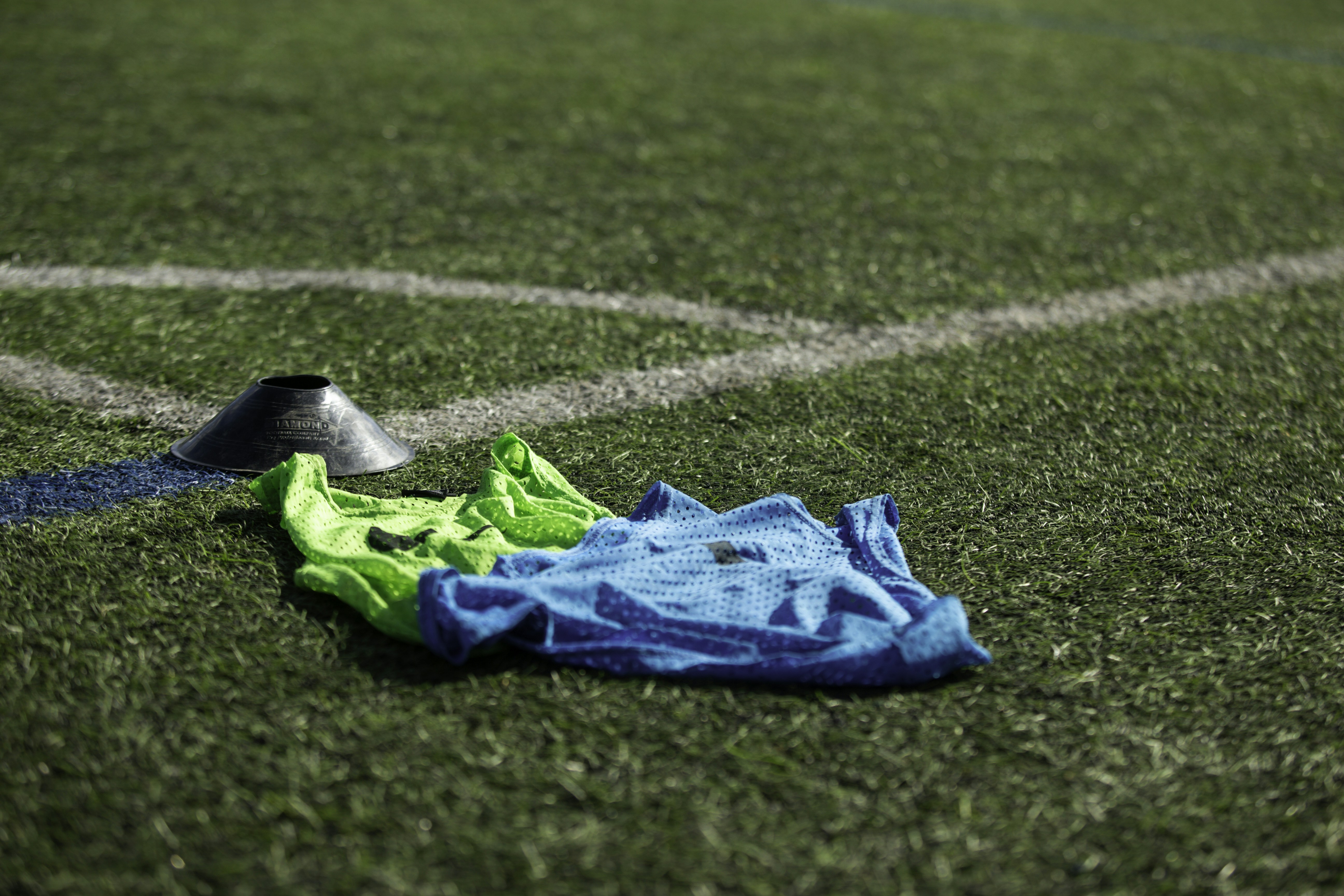 Two soccer shirts lay on the field.