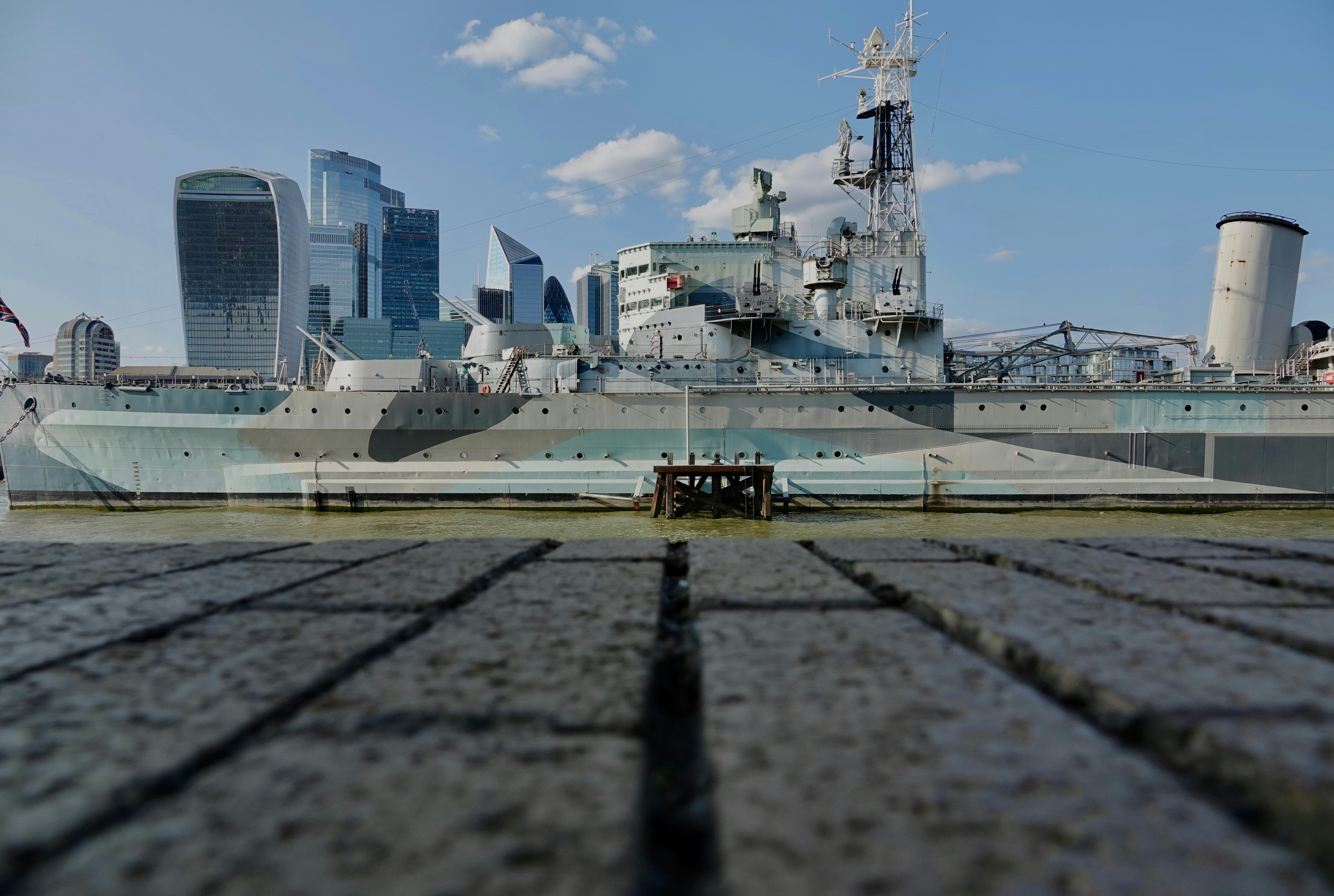Hull Against the Horizon: A Warship Framed by Glass Skyscrapers