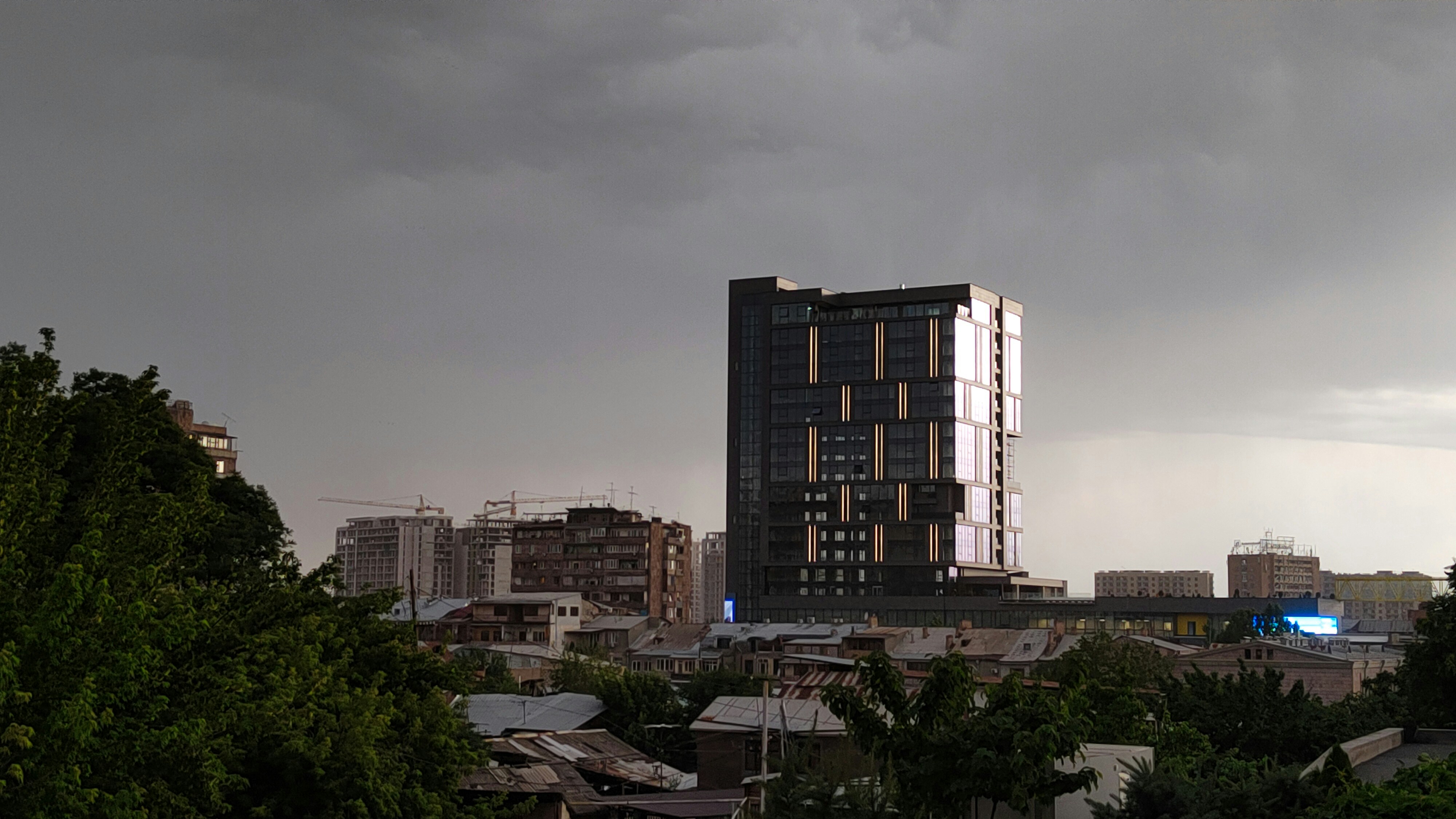 Glass Prism Rising Over a Cloud-Laden City