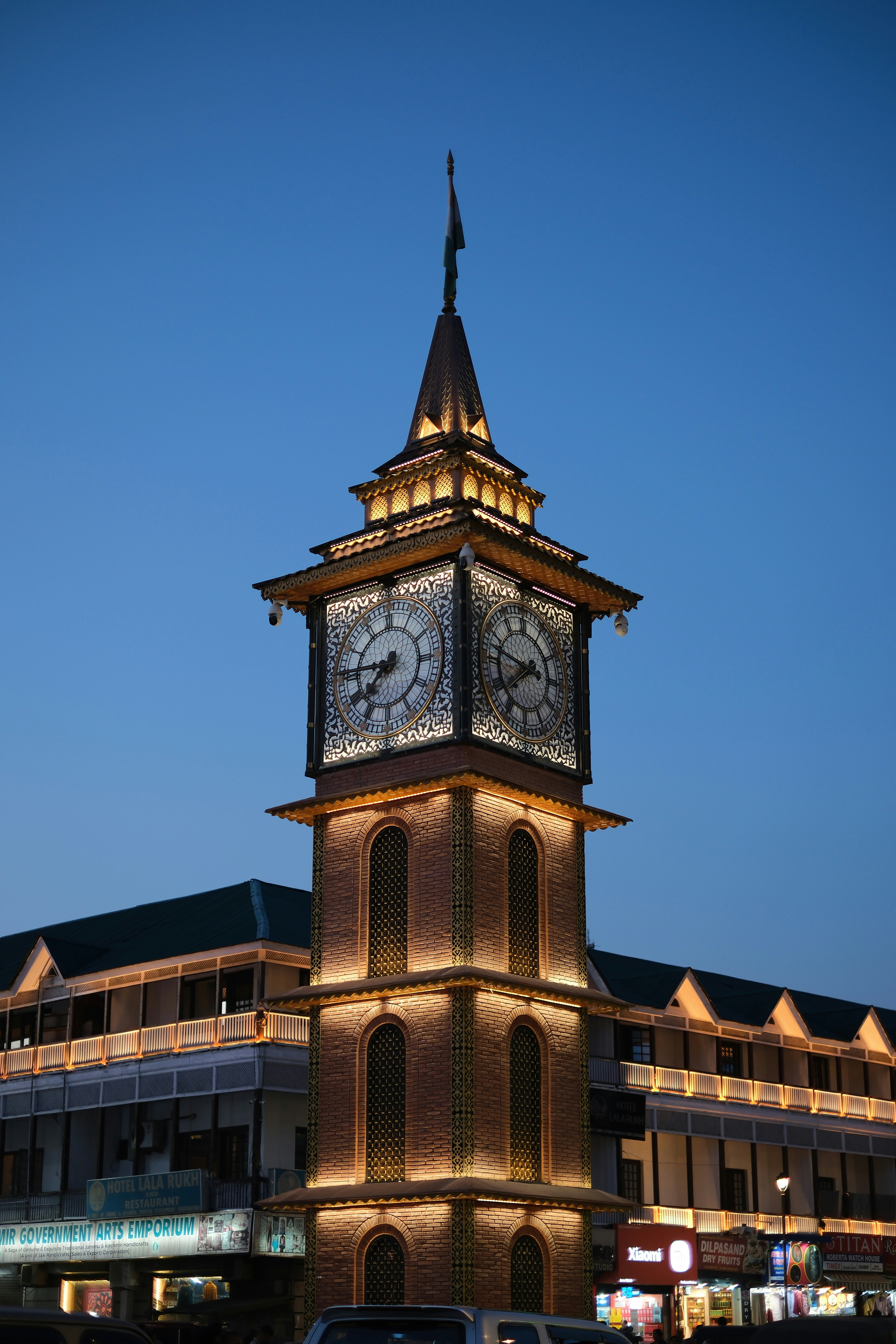 Blue Hour Clock Tower: Warm Glow on a Brick Spire Above a Lively Street