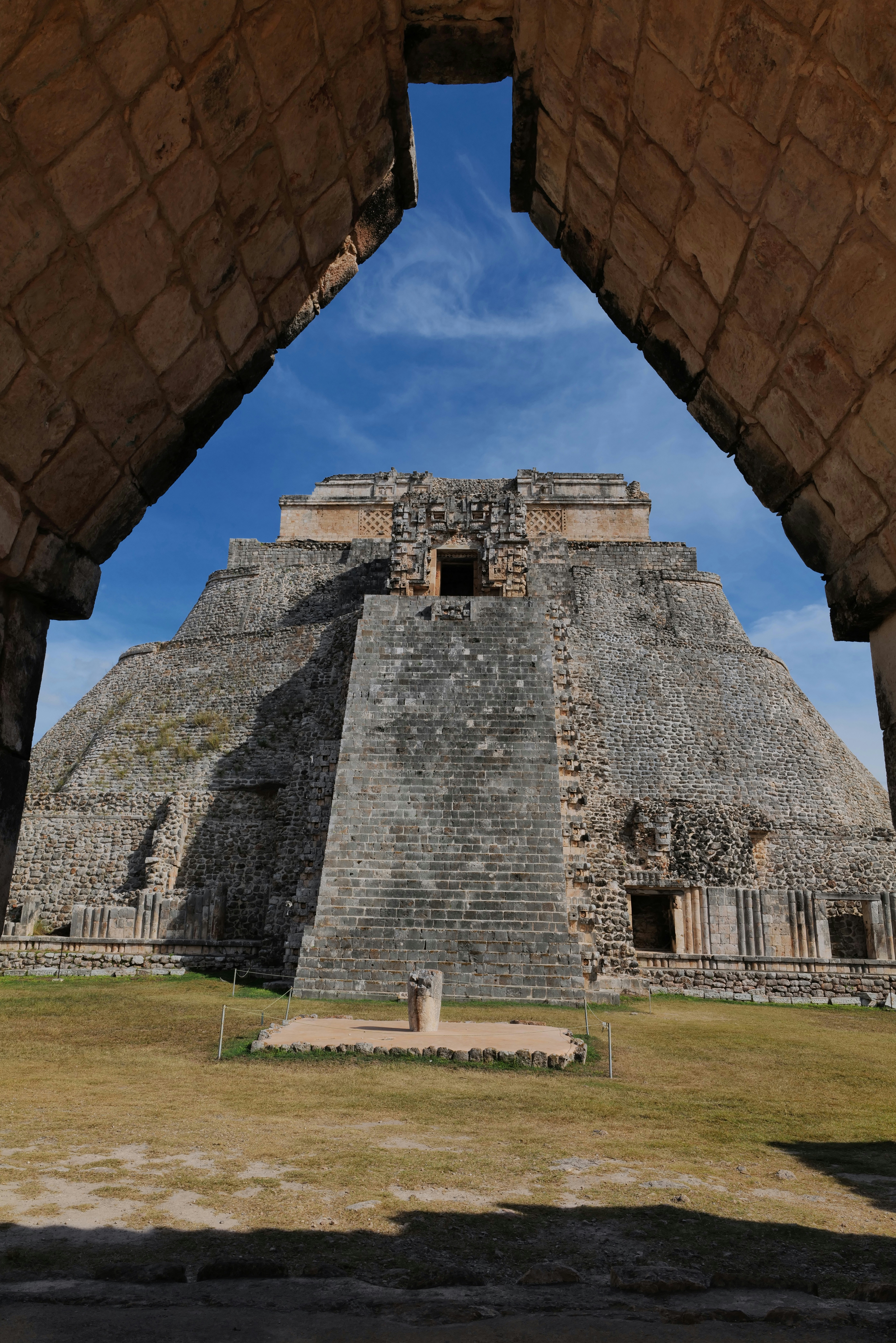 A majestic mayan pyramid viewed from an archway.