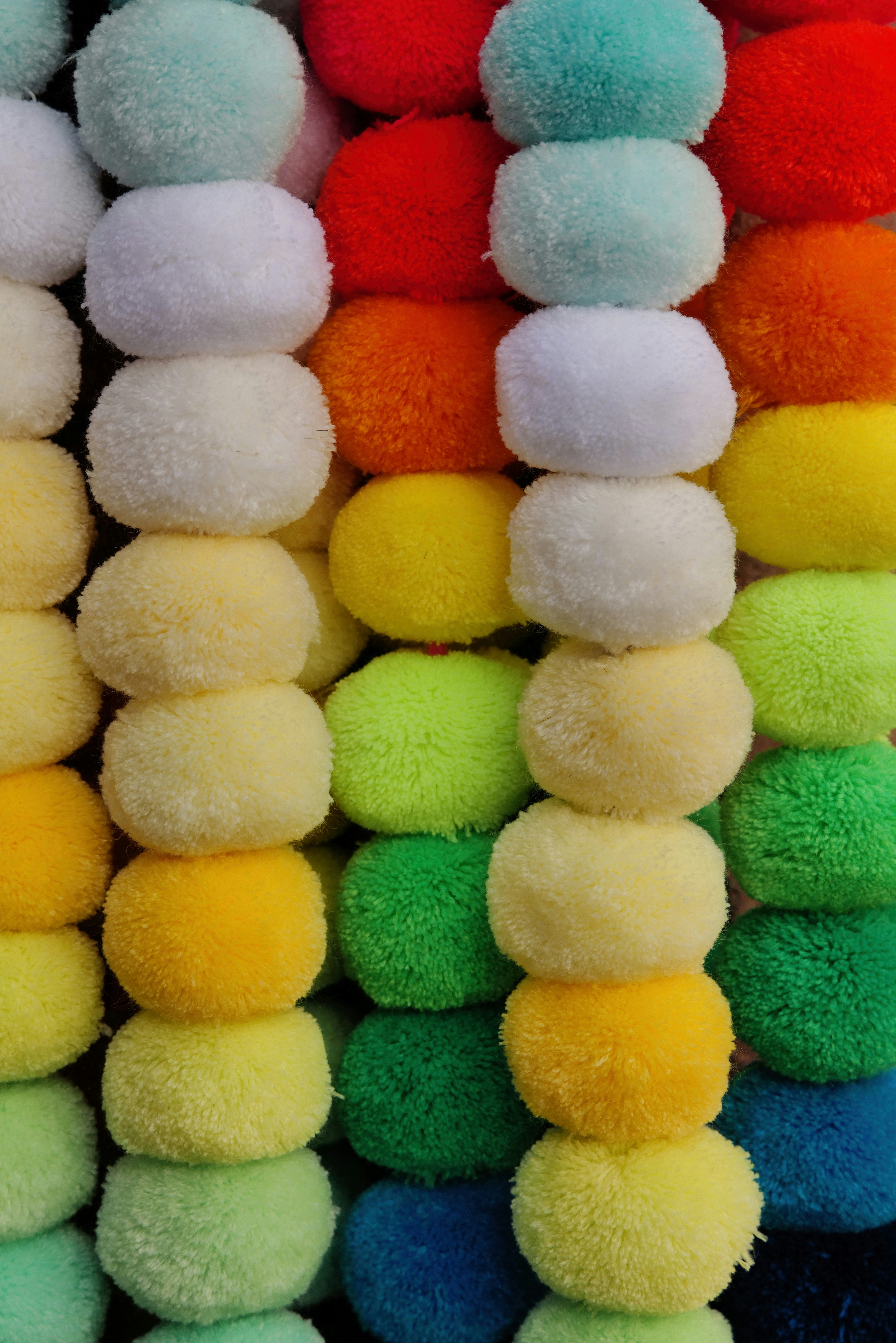A Spectrum of Softness: Colorful Pom-Poms in Harmony