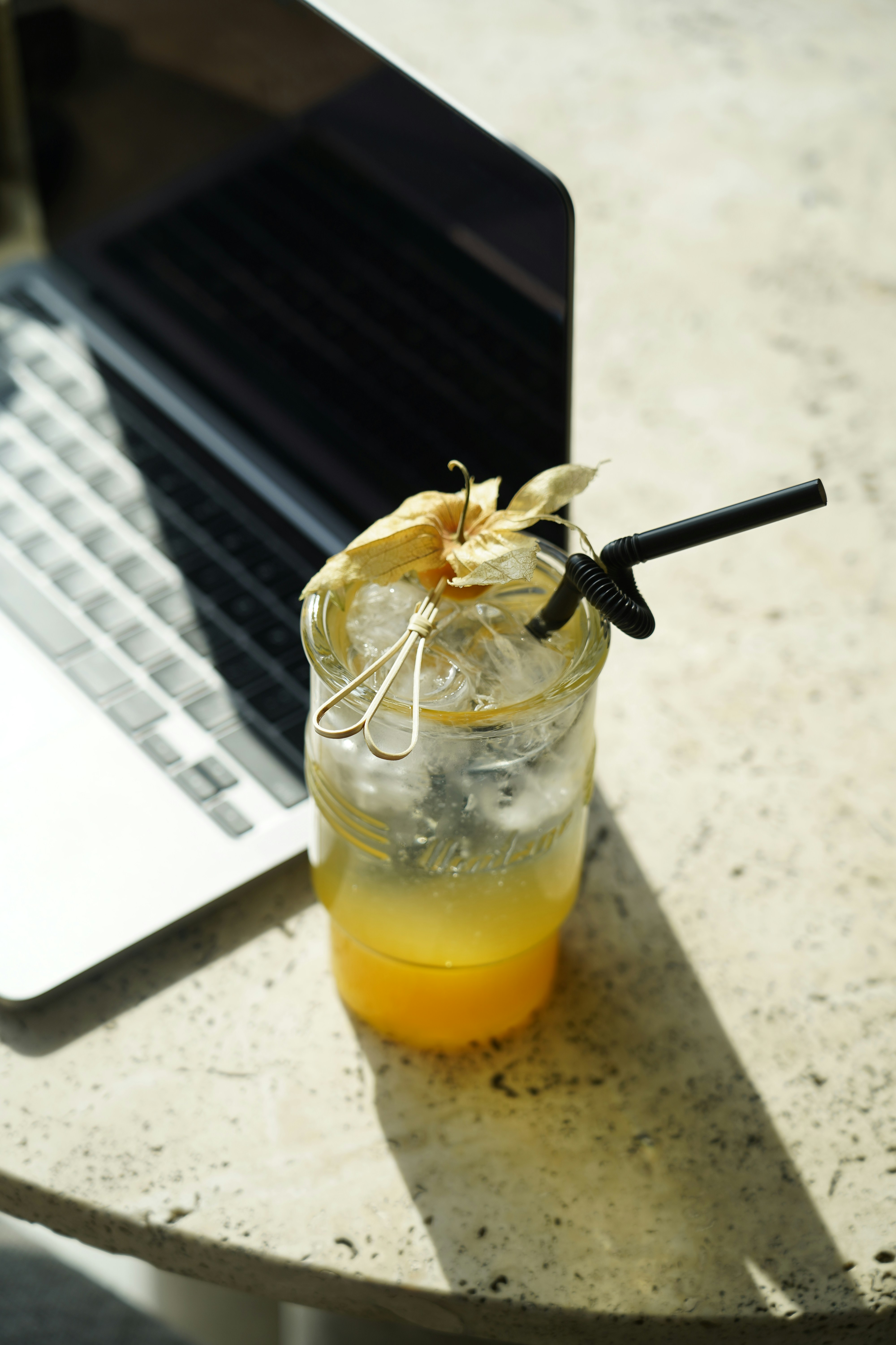 Citrus Glow at the Laptop Edge: Sunlit Pause on a Concrete Table