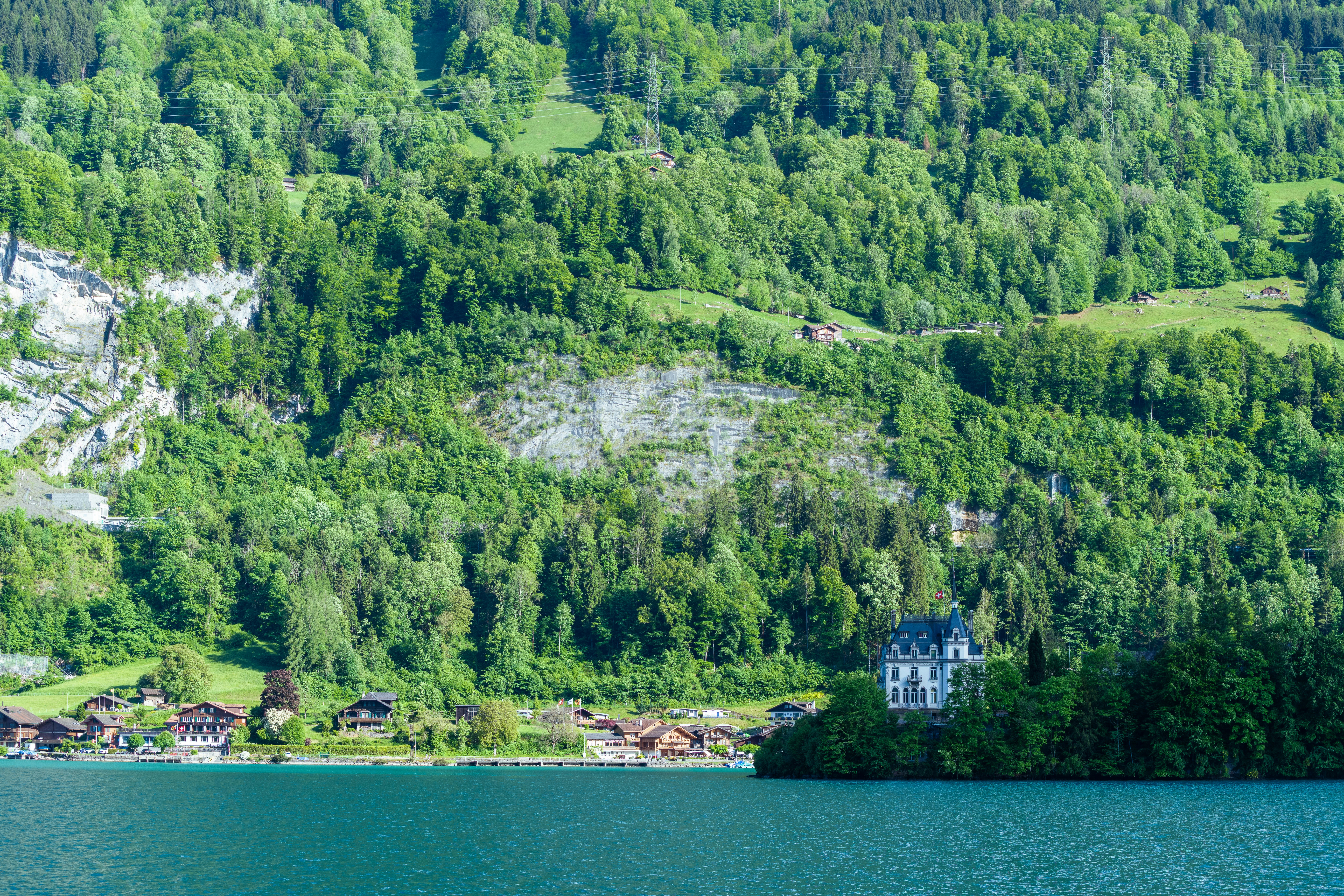 Charming lakeside villa nestled among lush green hills, reflecting a harmonious blend of nature and architecture.