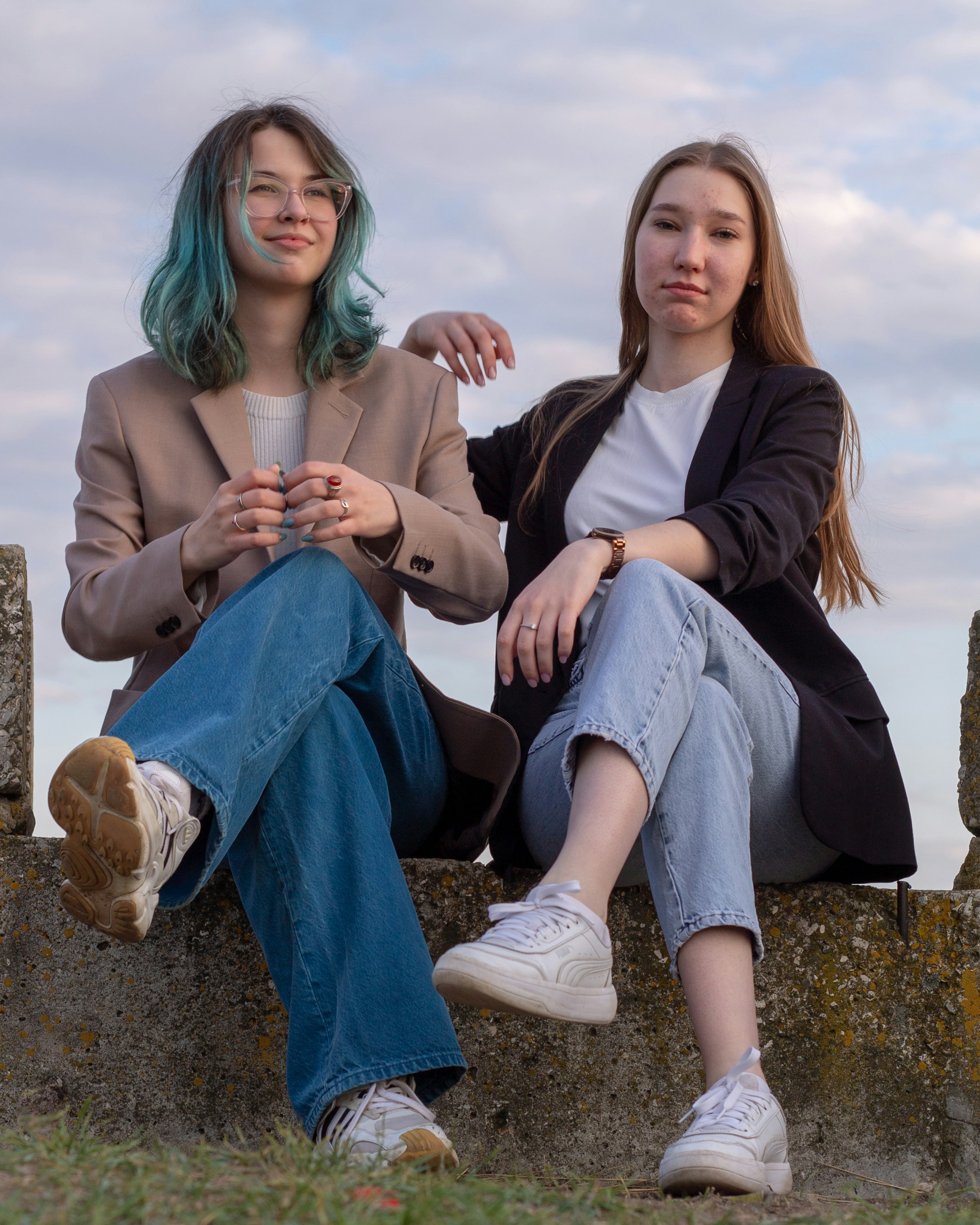 Weathered Wall, Modern Style: Friends in Blazers Under a Quiet Sky