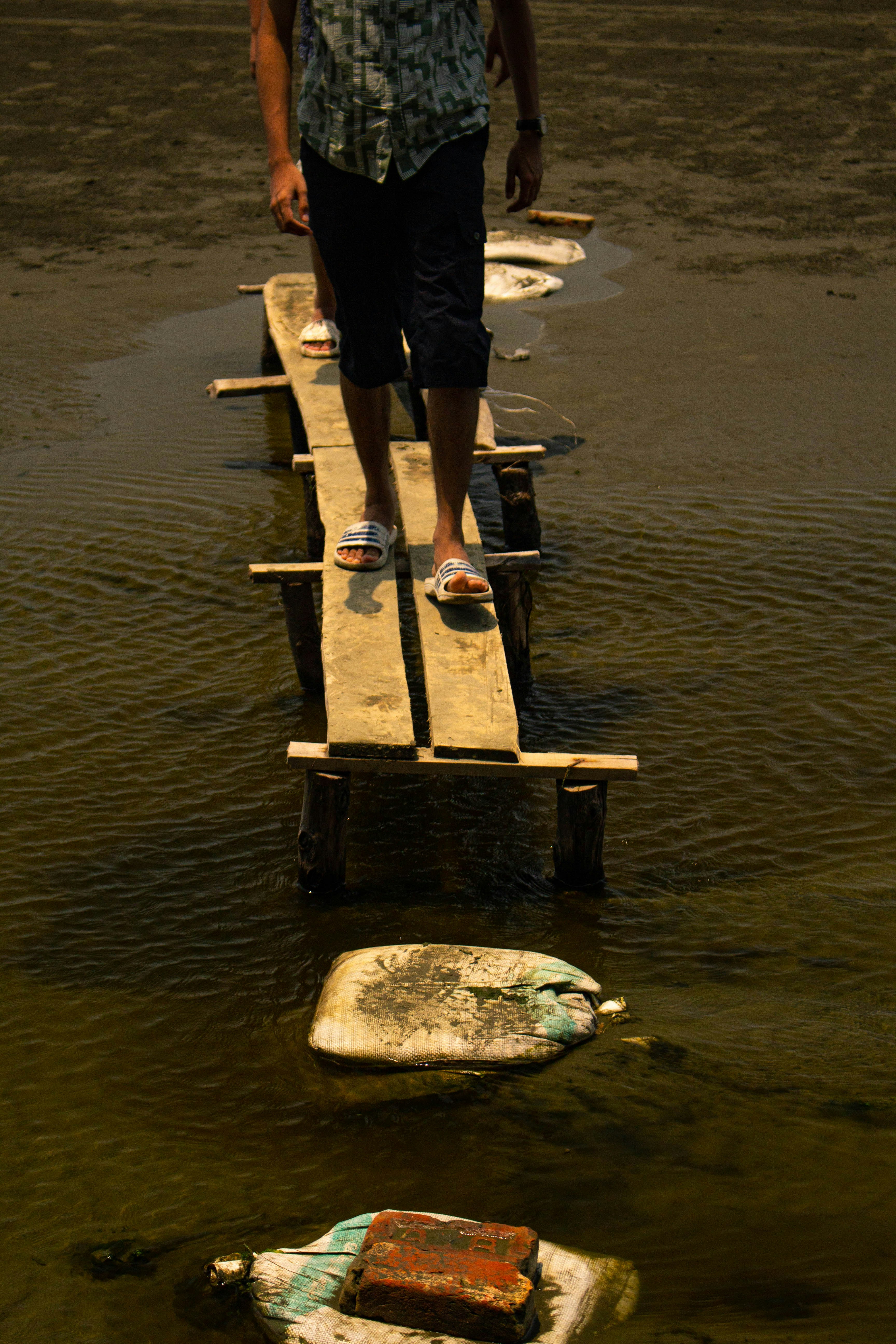 Man walks across a makeshift bridge.
