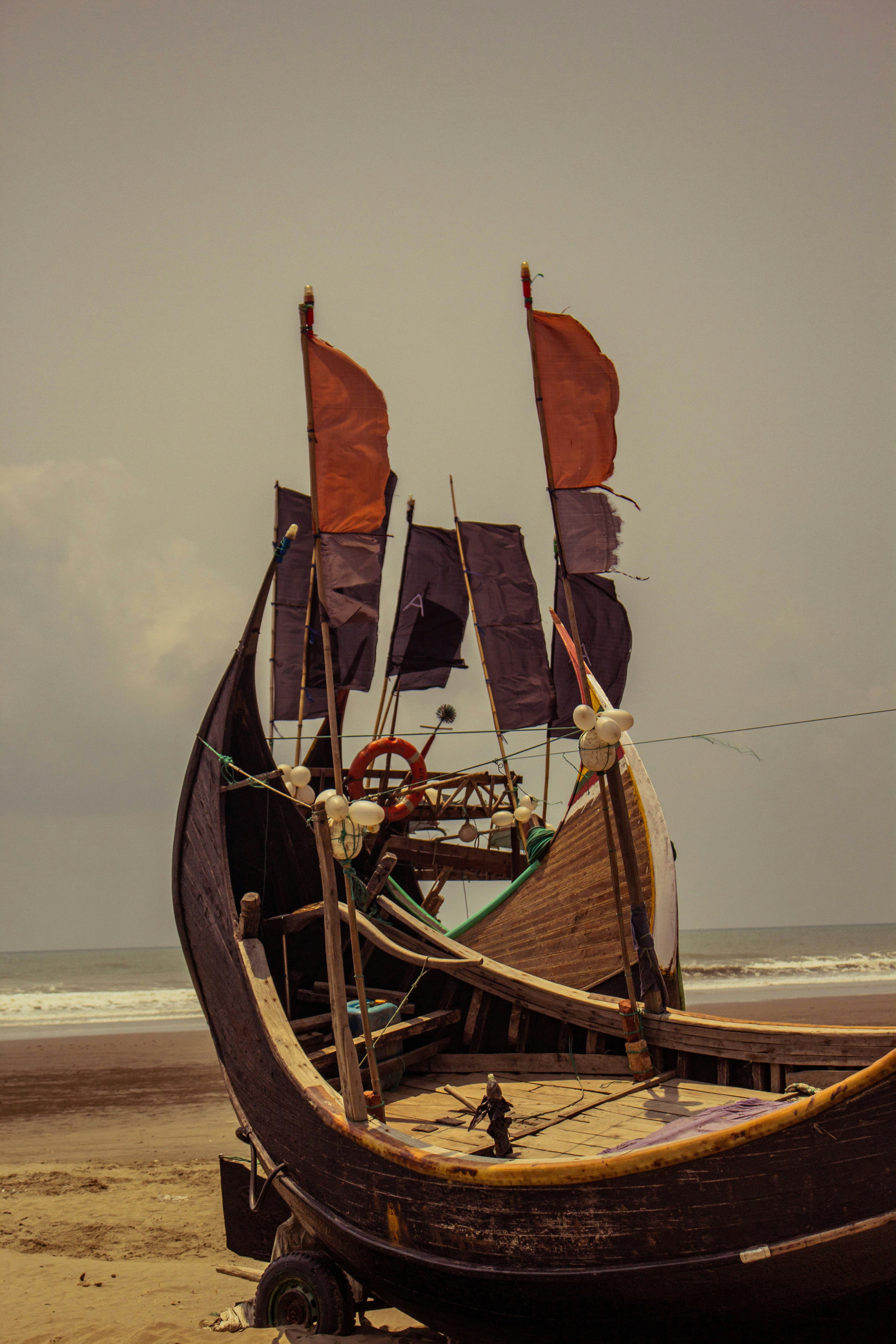Boats sit on the beach under a cloudy sky.