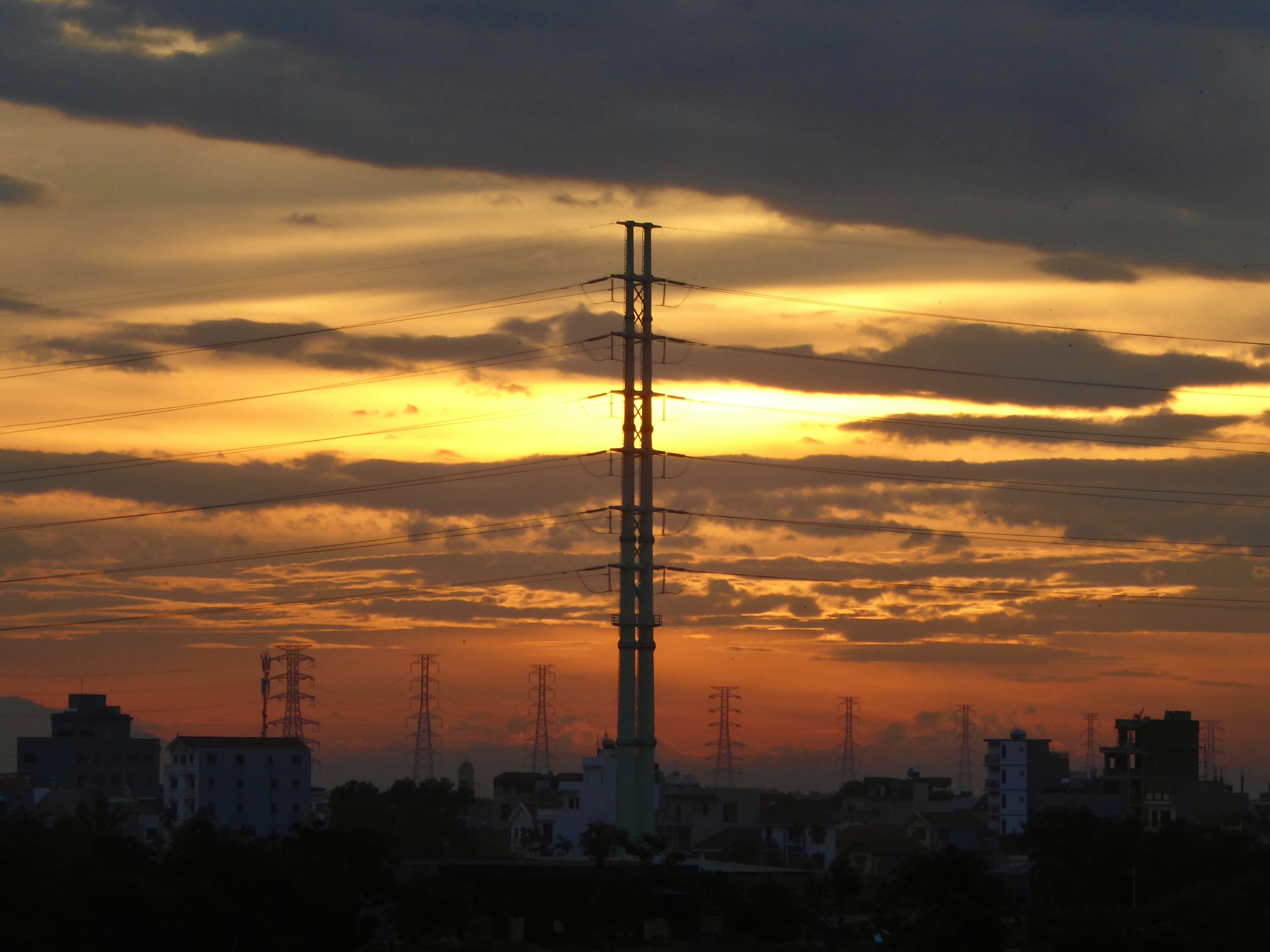 Power lines against a fiery sunset.
