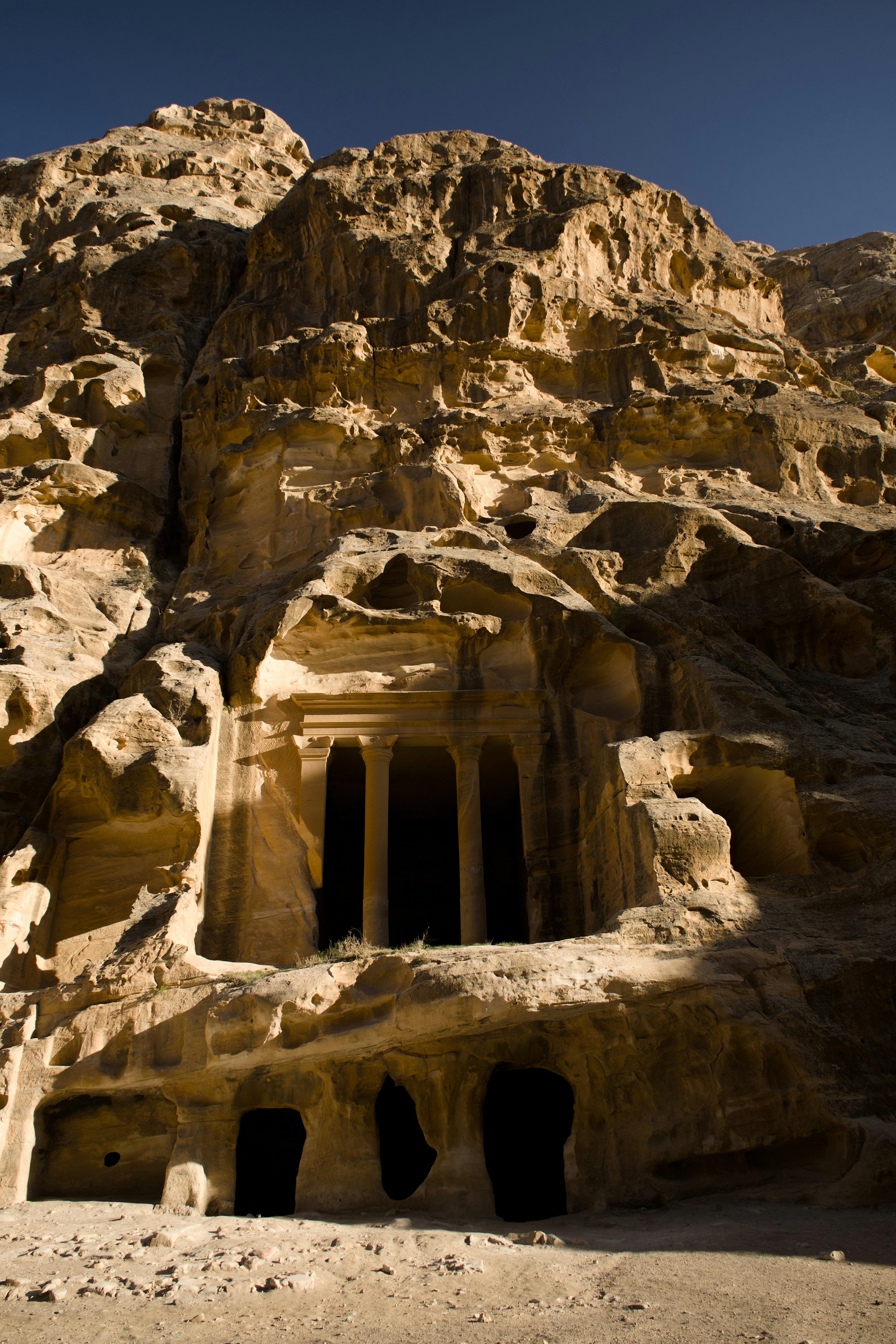 Ancient rock-cut tomb nestled in a sunlit cliff. photo – Free Desert ...