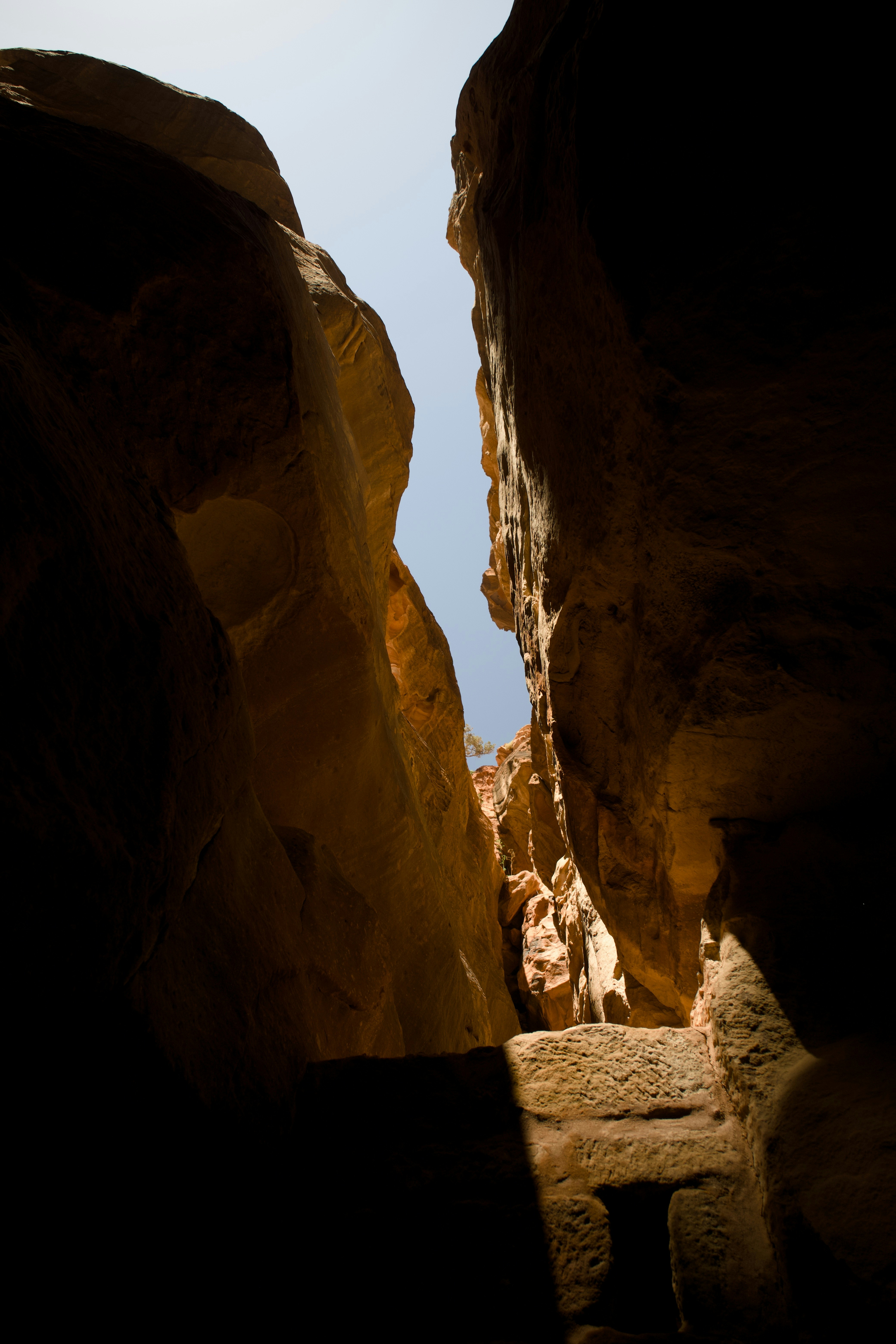 The sun shines through a narrow canyon passage.