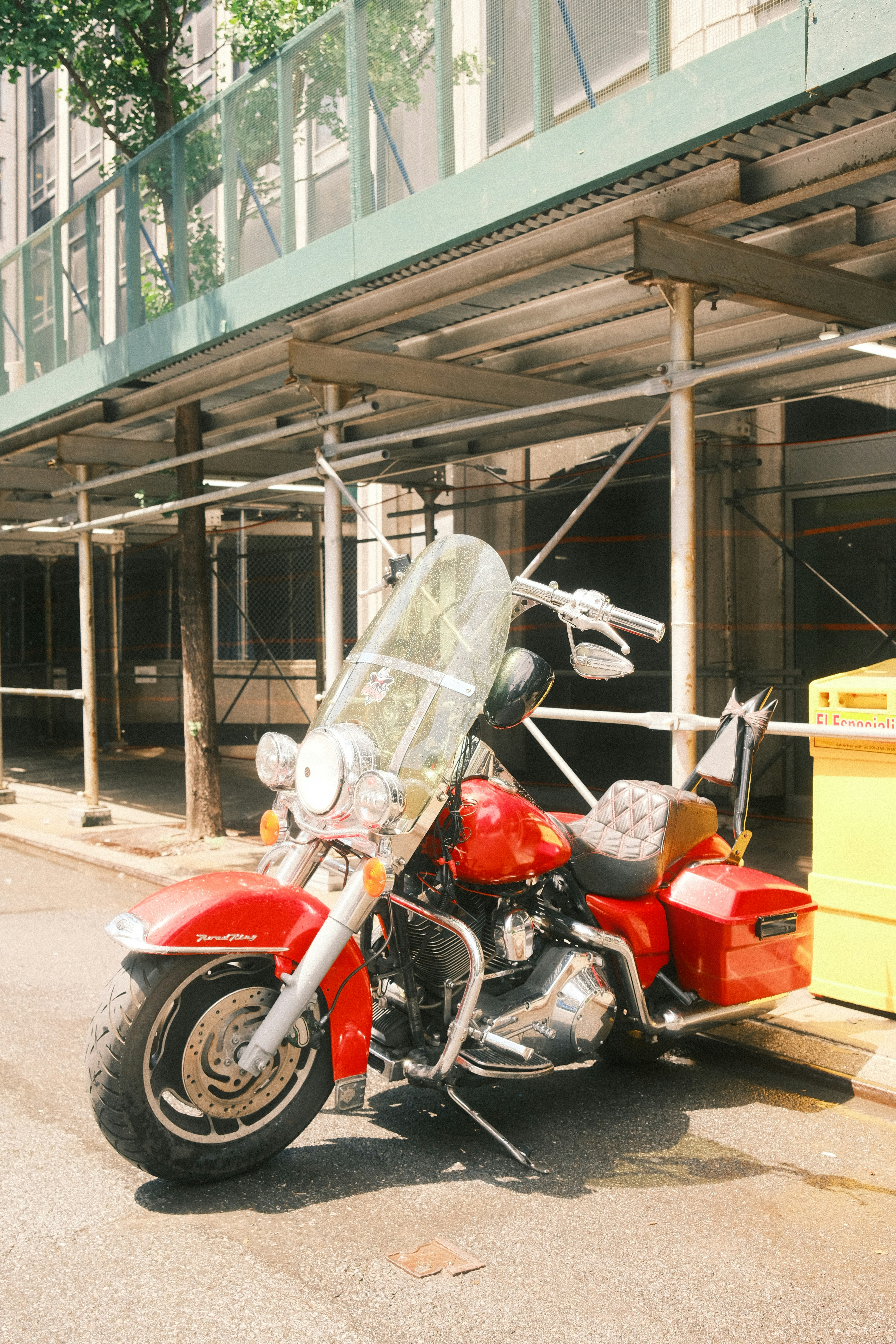 A red motorcycle is parked under scaffolding. photo – Free Street ...