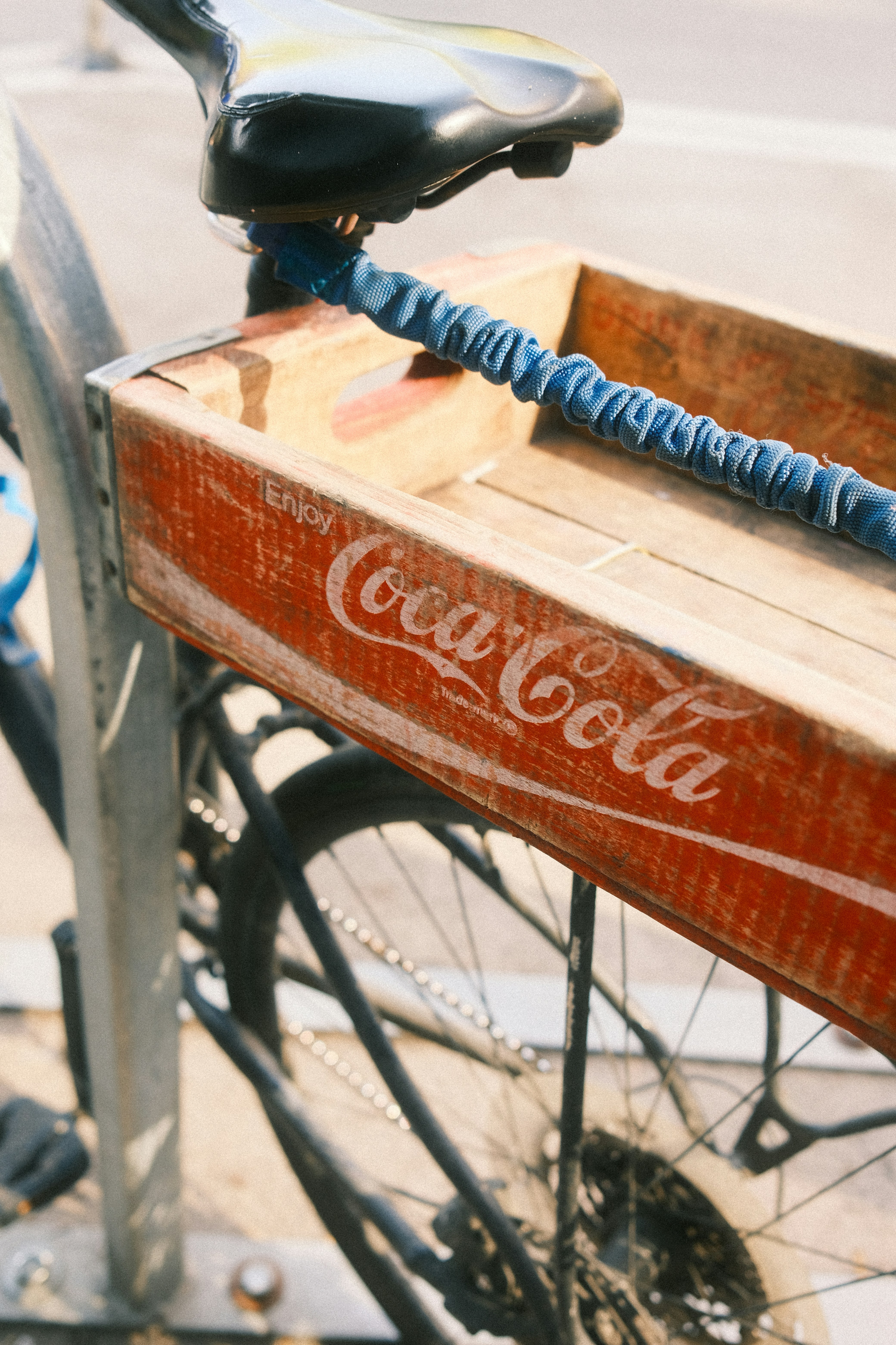 A coca-cola crate is attached to a bicycle.