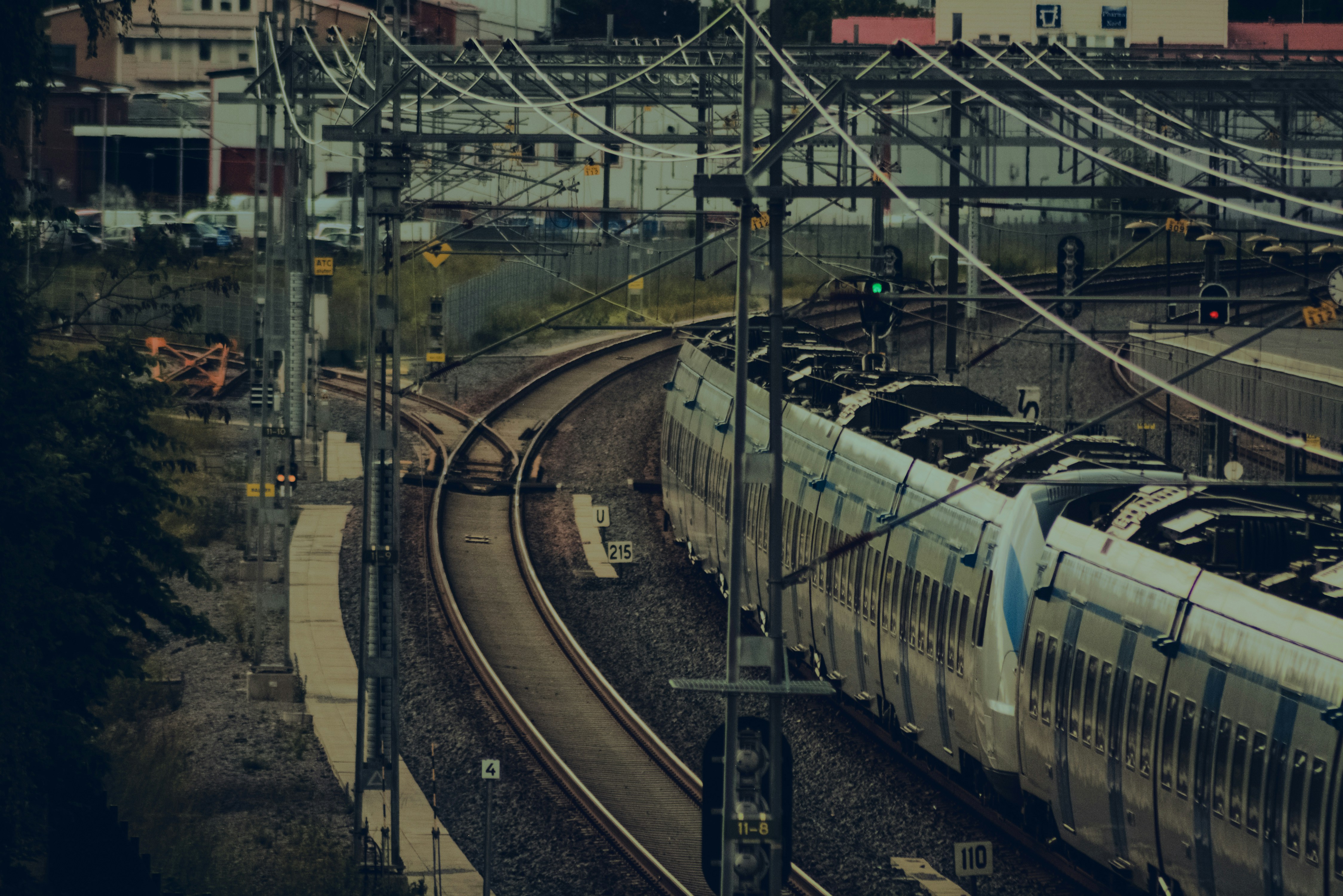 A train curves through tracks near buildings. photo – Free Travel Image ...
