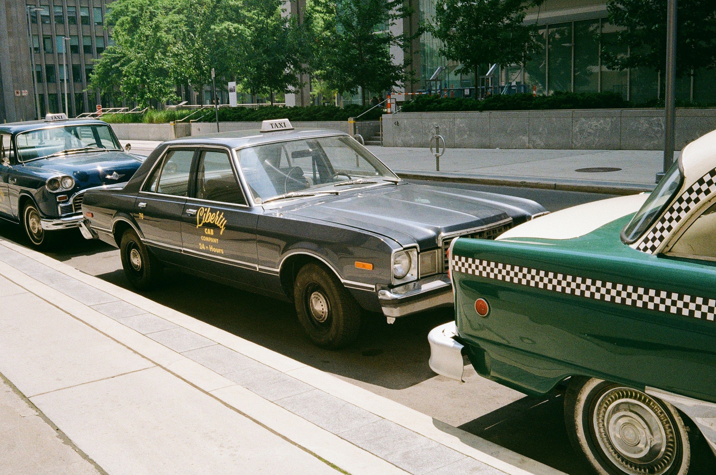 Los taxis antiguos están aparcados a lo largo de una calle de la ciudad ...